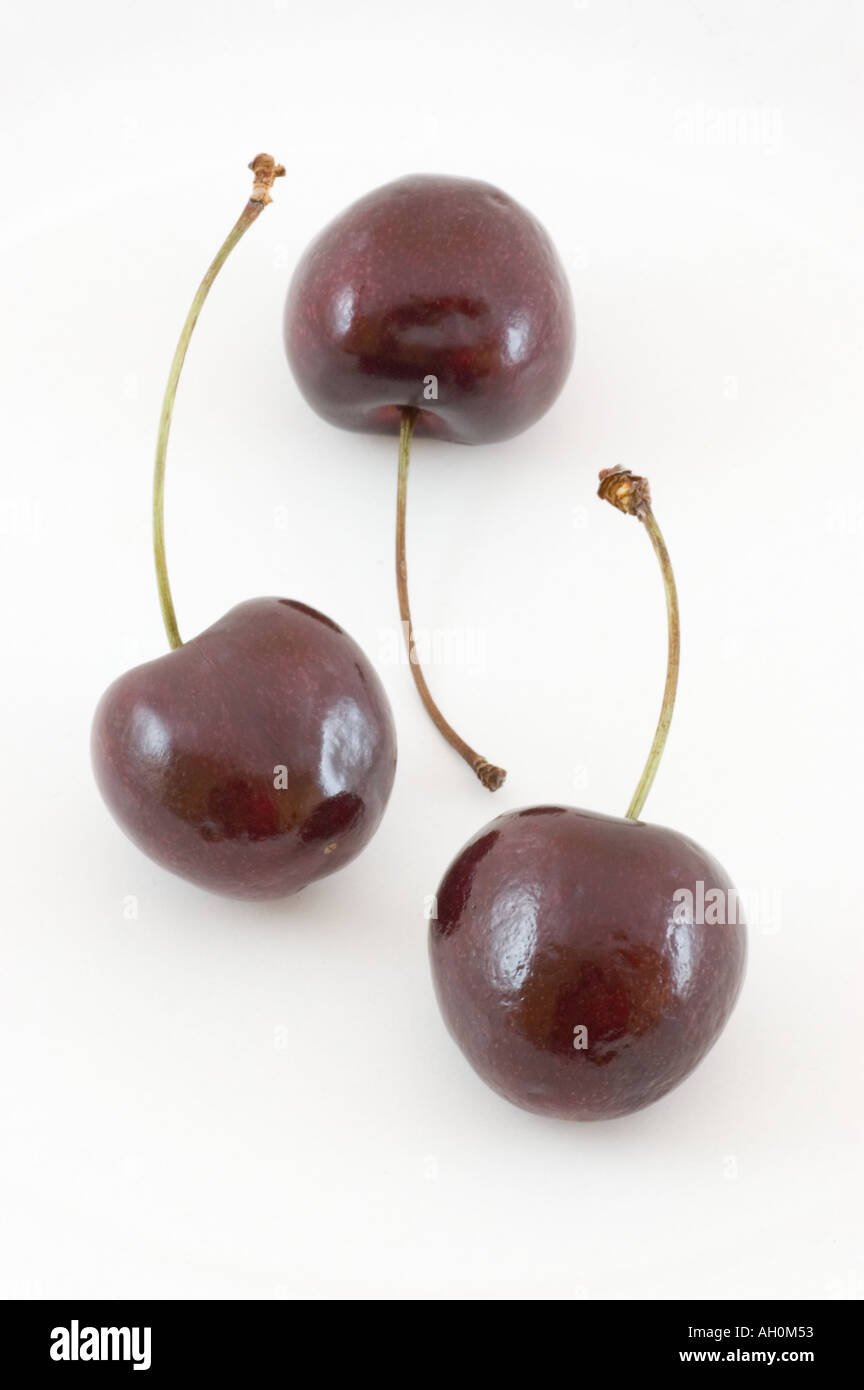 Three cherries against a white background Stock Photo - Alamy