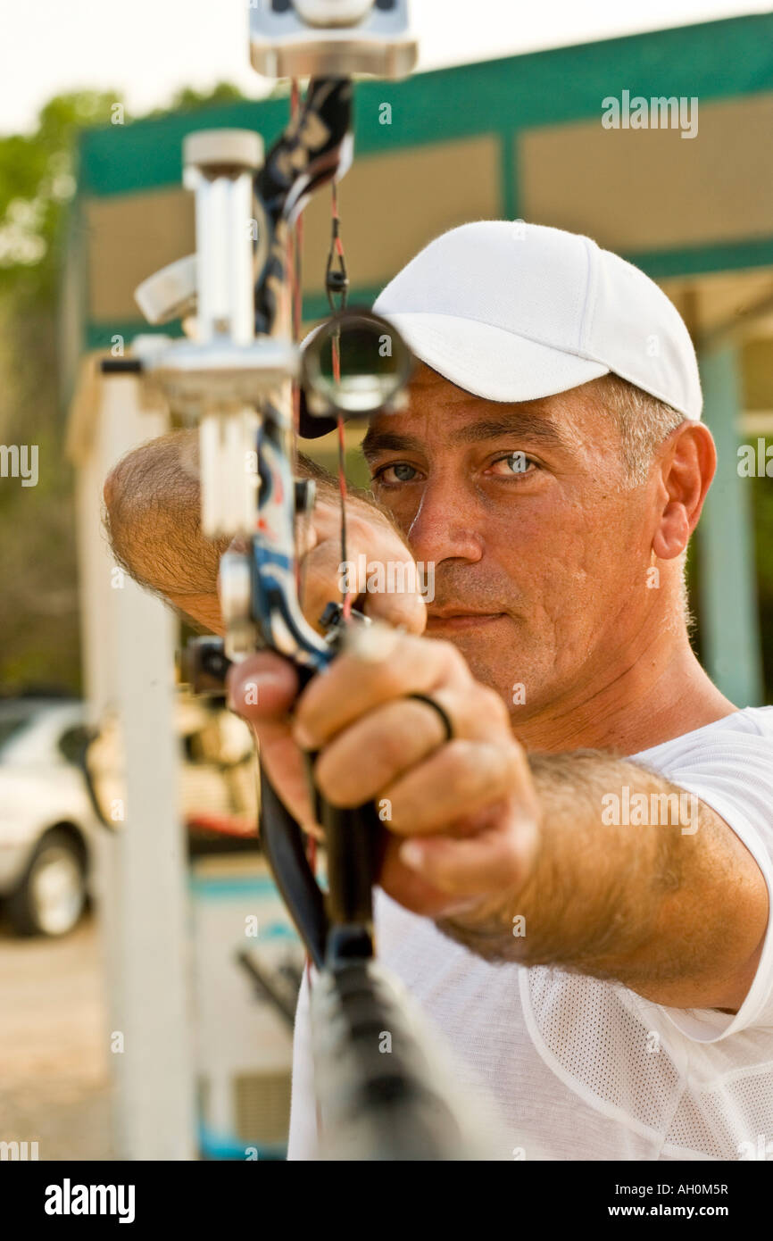 Male archer holding bow with arrow ready to shoot at target Stock Photo ...