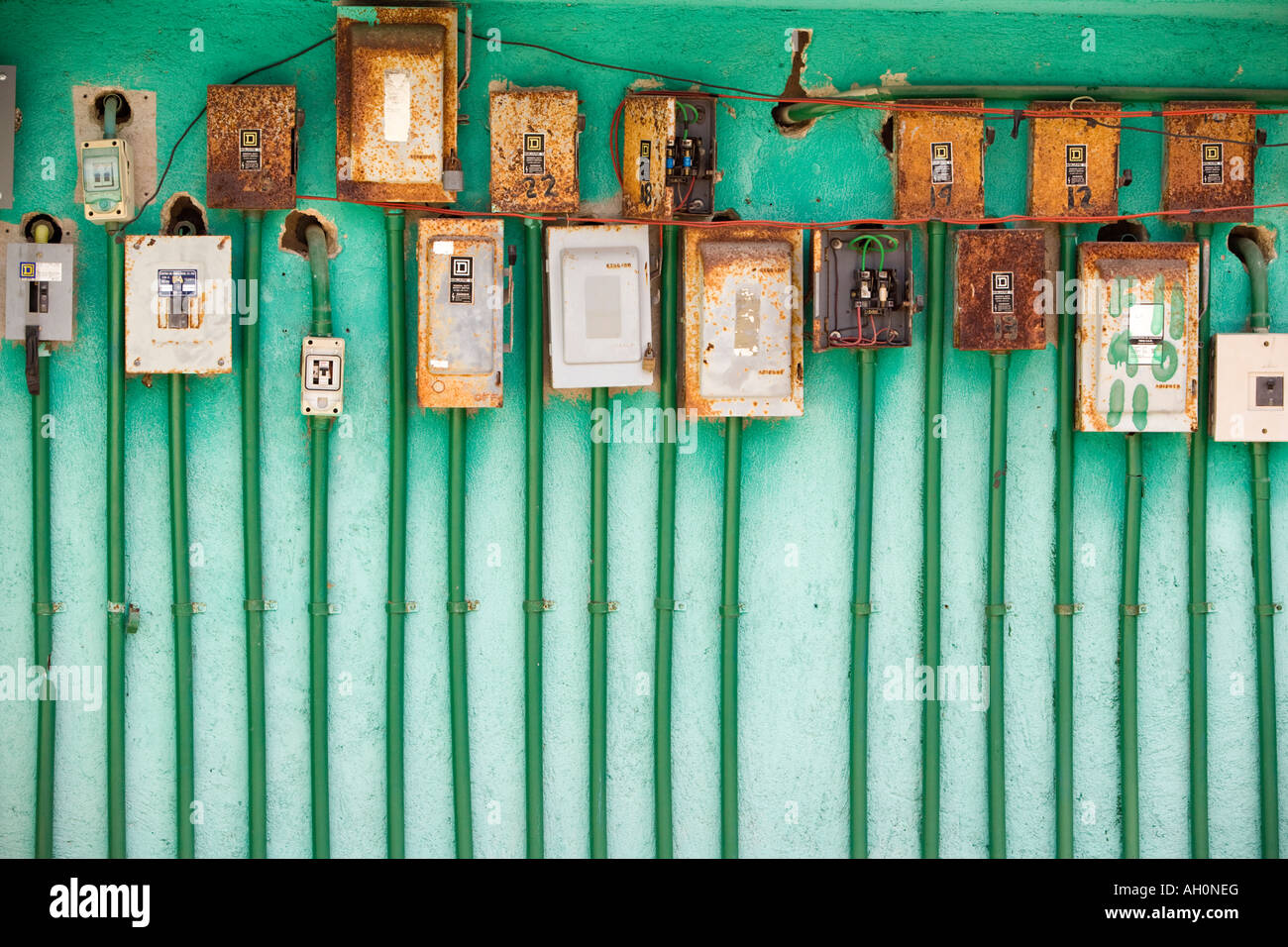 Many rusted electric panels on a green wall Stock Photo - Alamy