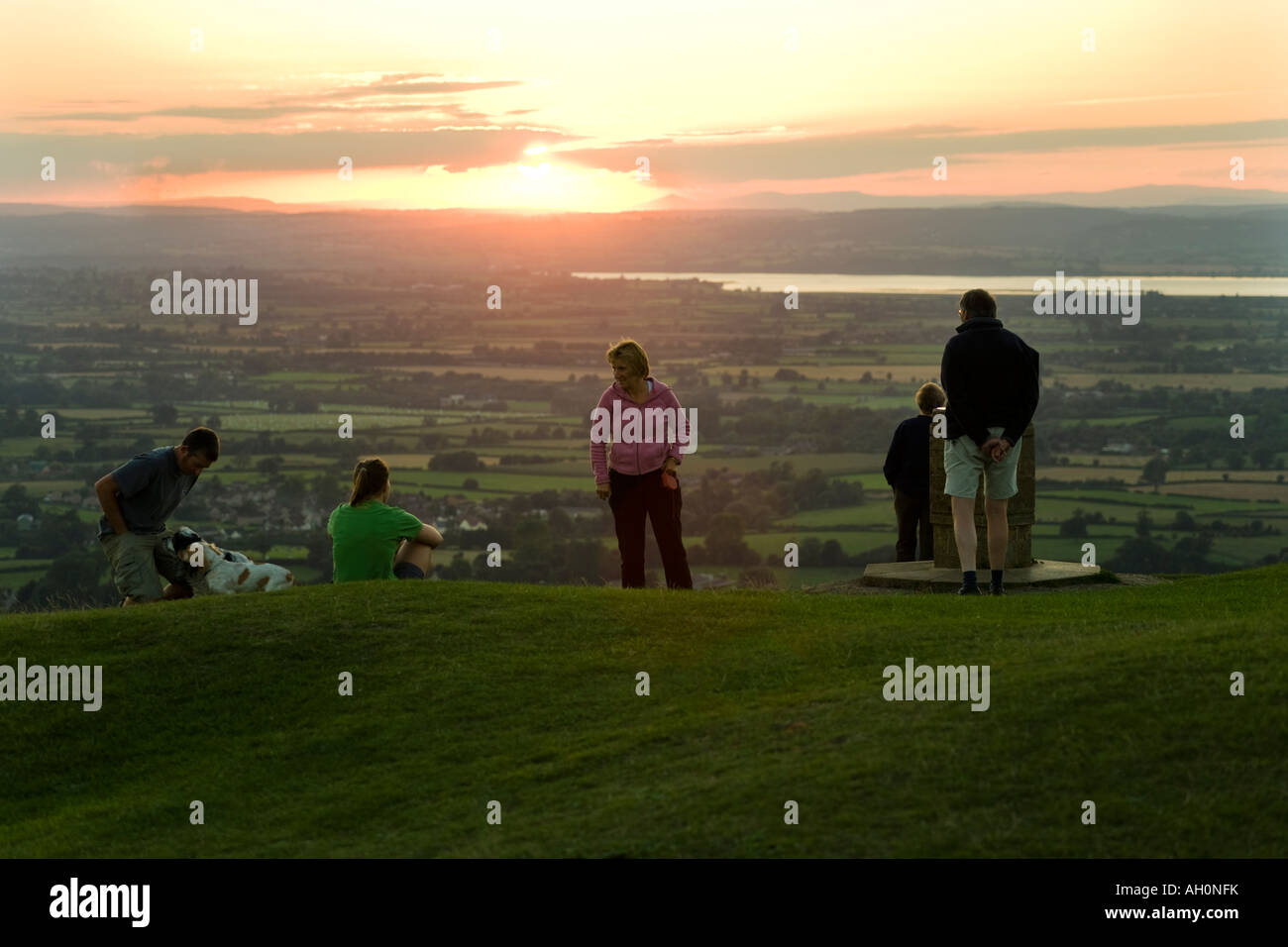 A family watching the sunset from the Cotswold viewpoint on Frocester ...
