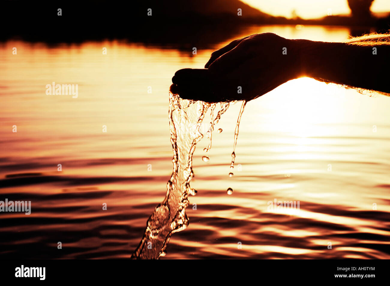 Cupped hands and water at sunset. Silhouette. India Stock Photo - Alamy