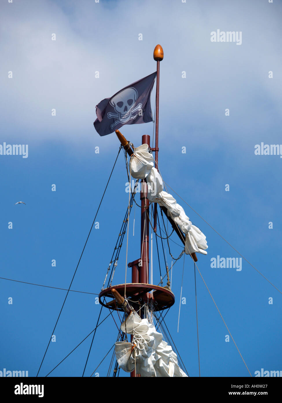 Skull and bones jolly roger pirates flag waving in the mast of a tall ...