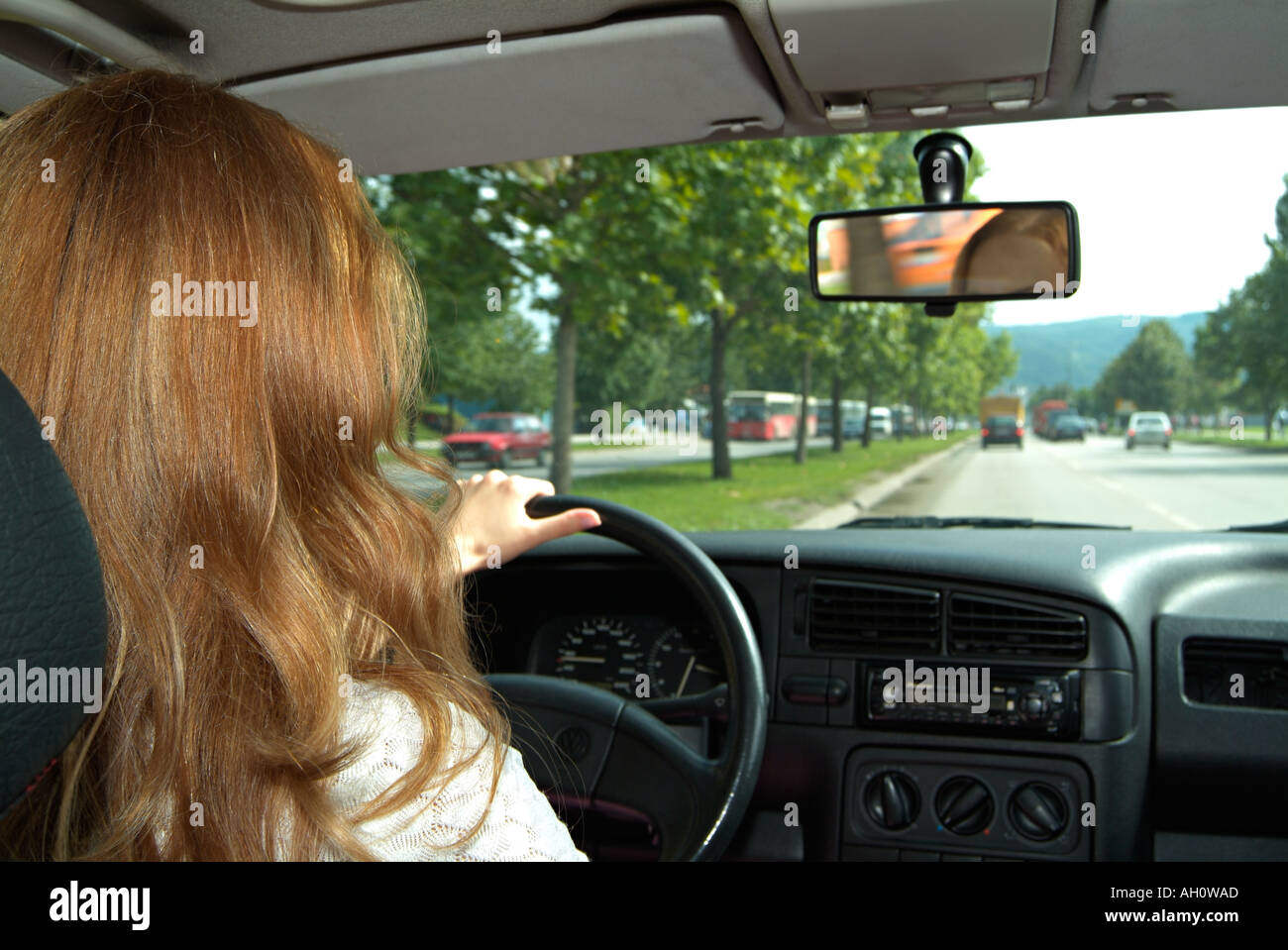 Driving Woman Drives Her car Along an Urban Road Stock Photo - Alamy