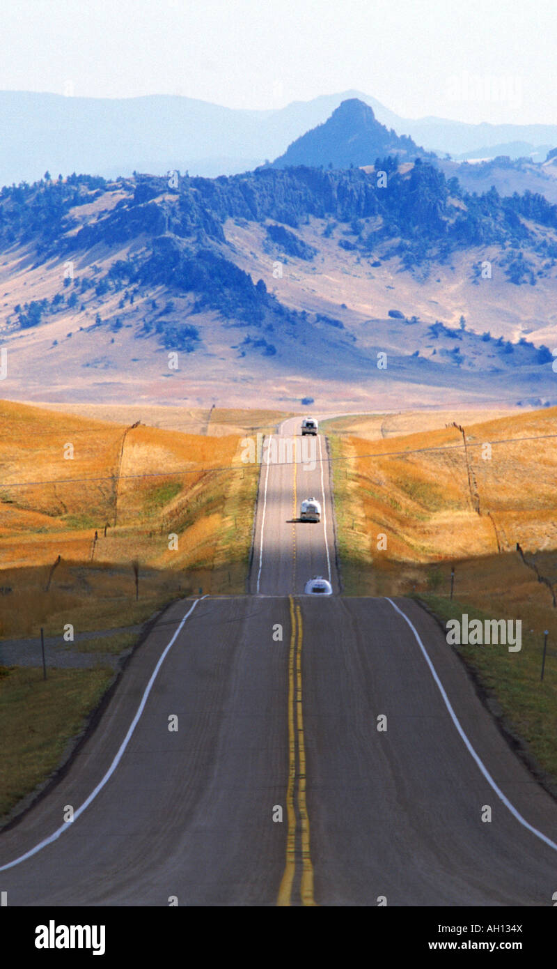 Straight road reaching across plains of Montana toward Rocky Mountains ...