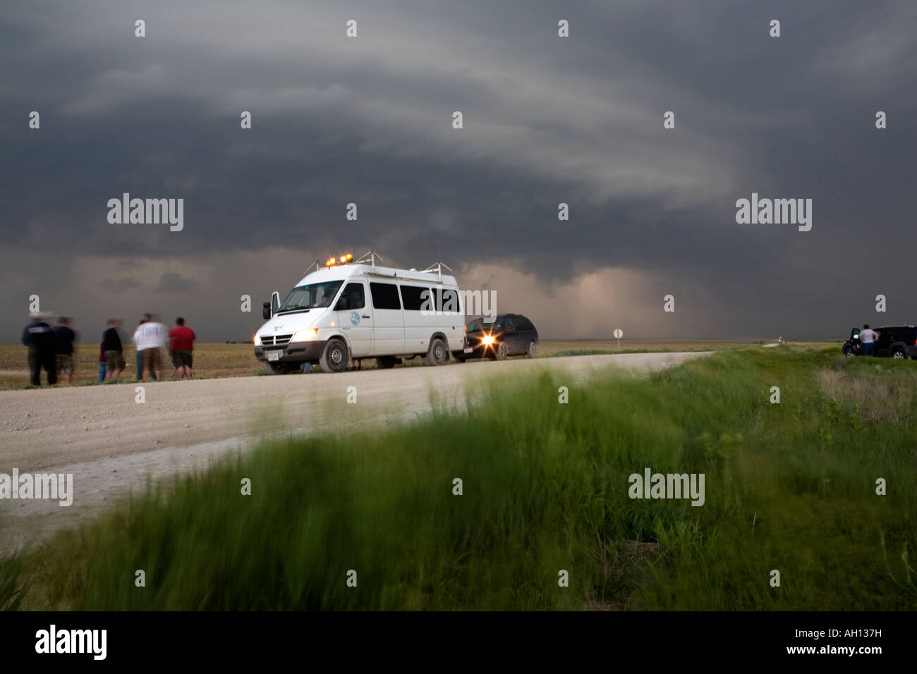 Storm chasers and their vehicles watch a supercell thunderstorm in ...