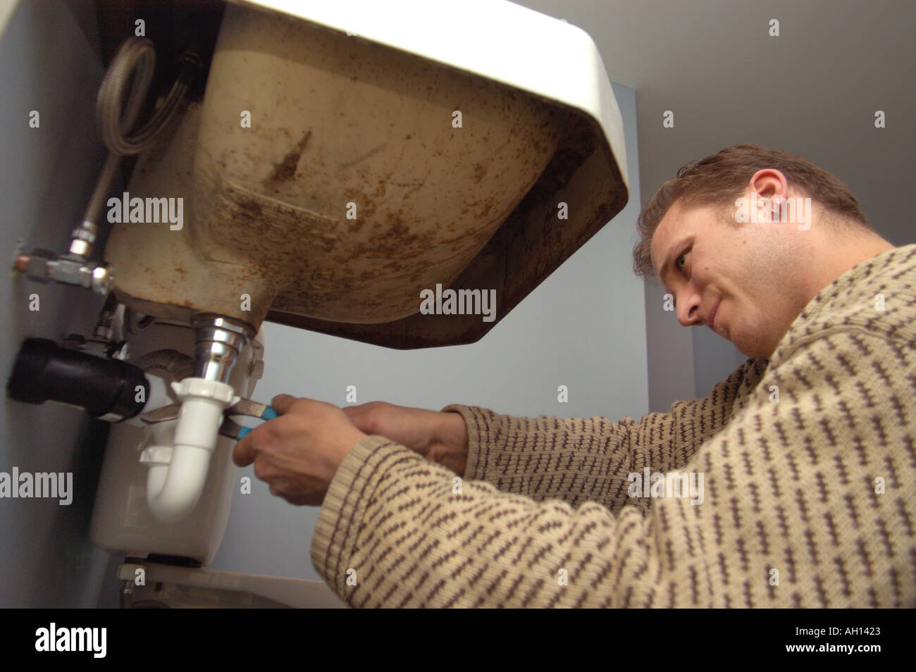 Homeowner fixing his sink Stock Photo - Alamy