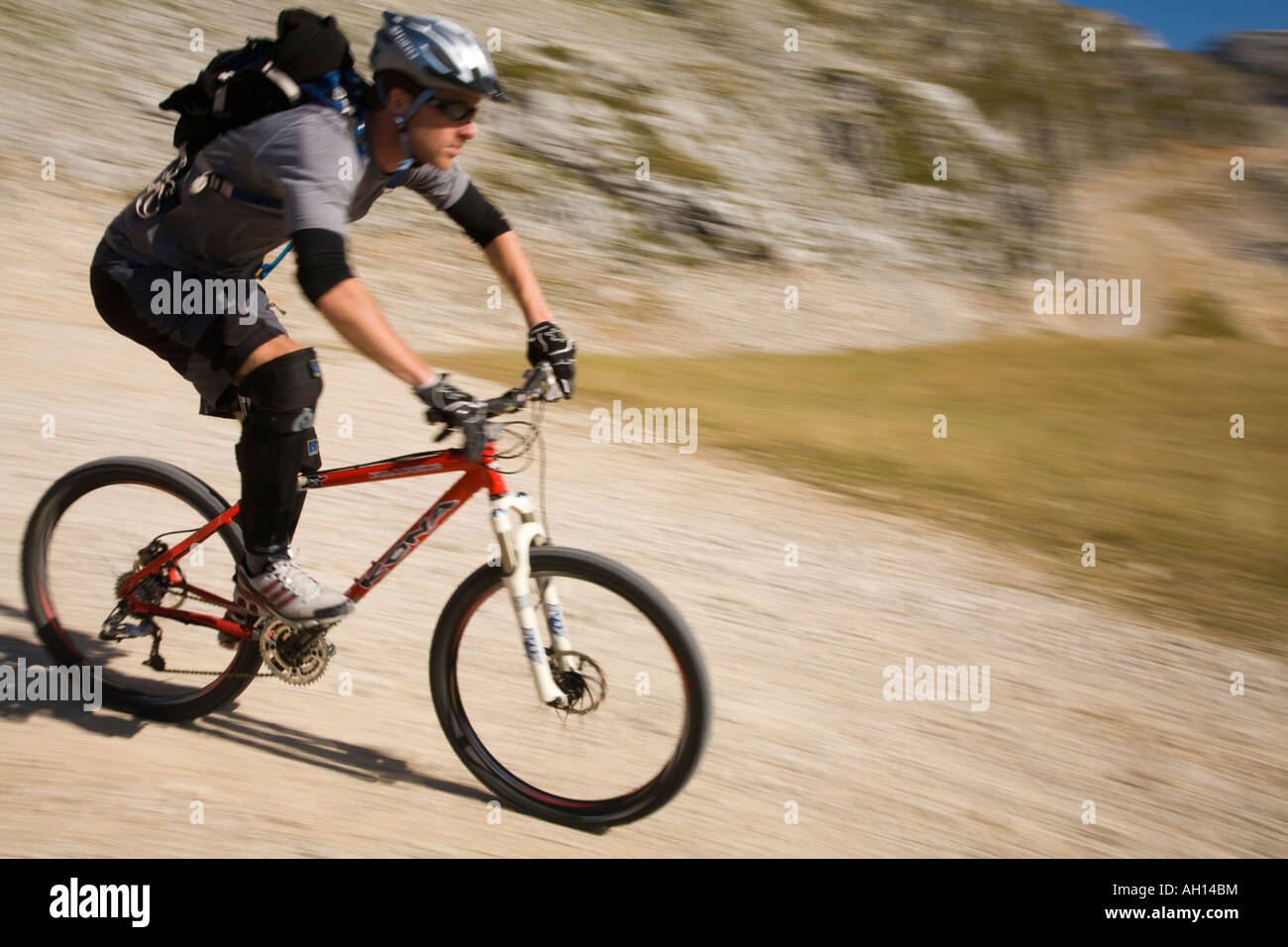 Mountain biker racing down access road Stock Photo - Alamy