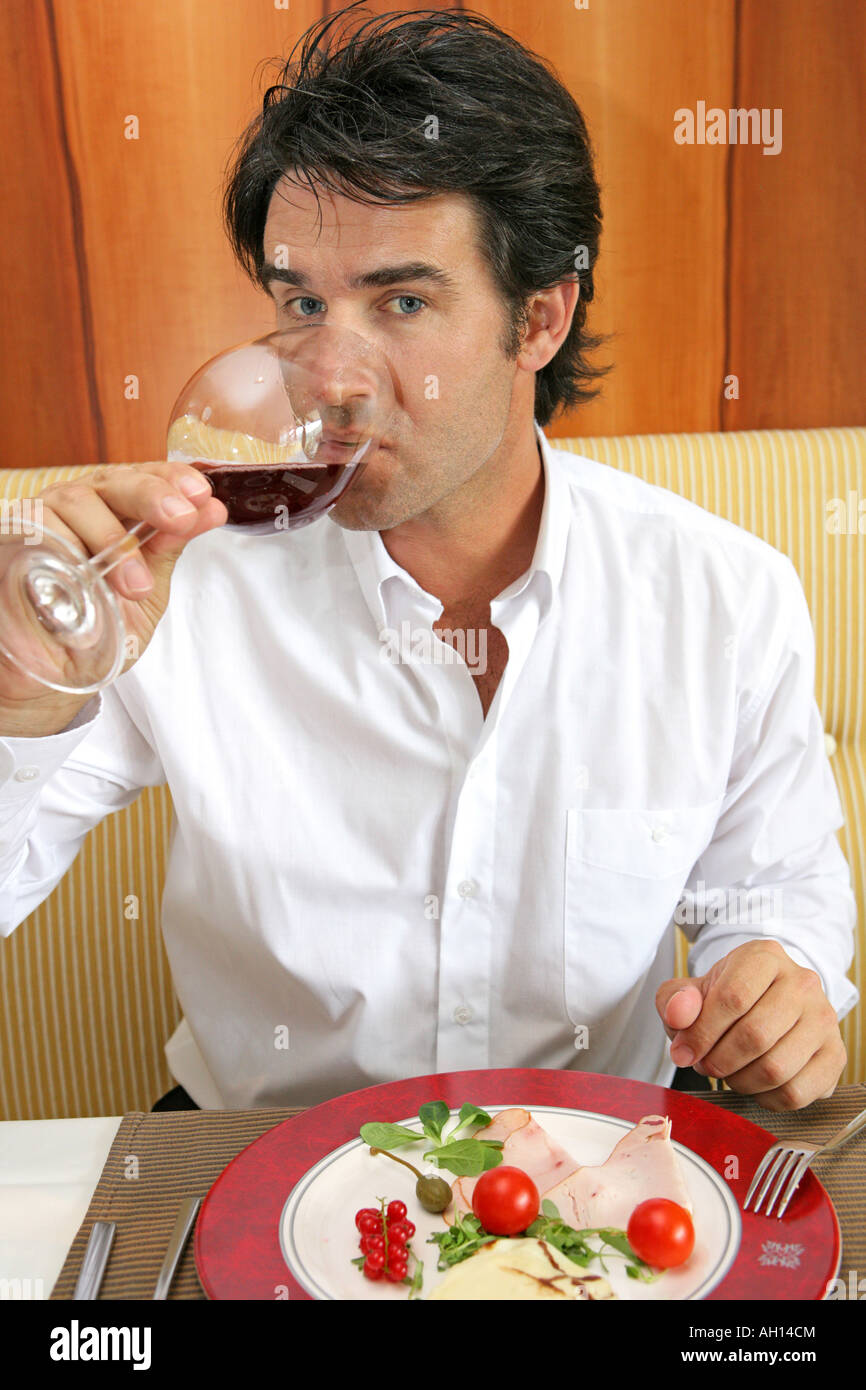 man eating in a restaurant and drinking red wine Stock Photo - Alamy