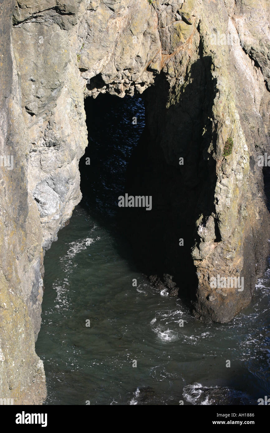A coastal cave with a black rectangular ribbon opening with the ocean ...