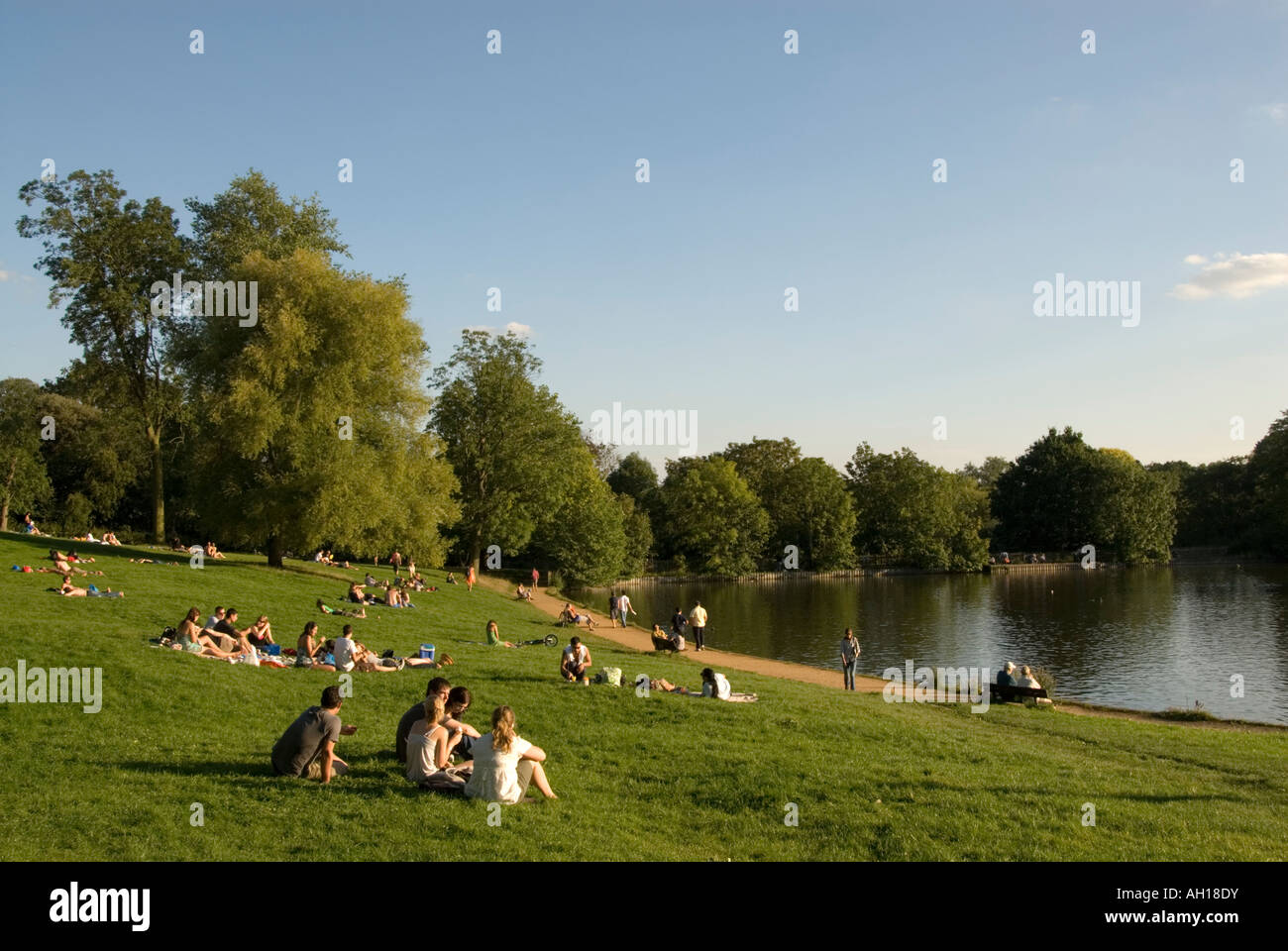 Young people relaxing beside Highgate pond on Hampstead Heath, London ...