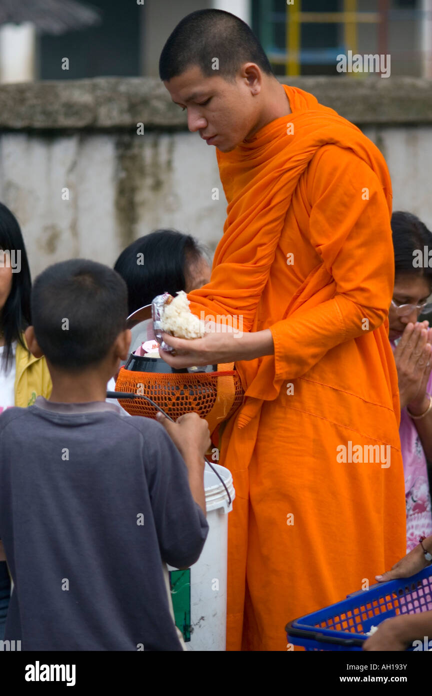 Monk giving alms to a begging child. Luang Prabang, Laos Stock Photo ...