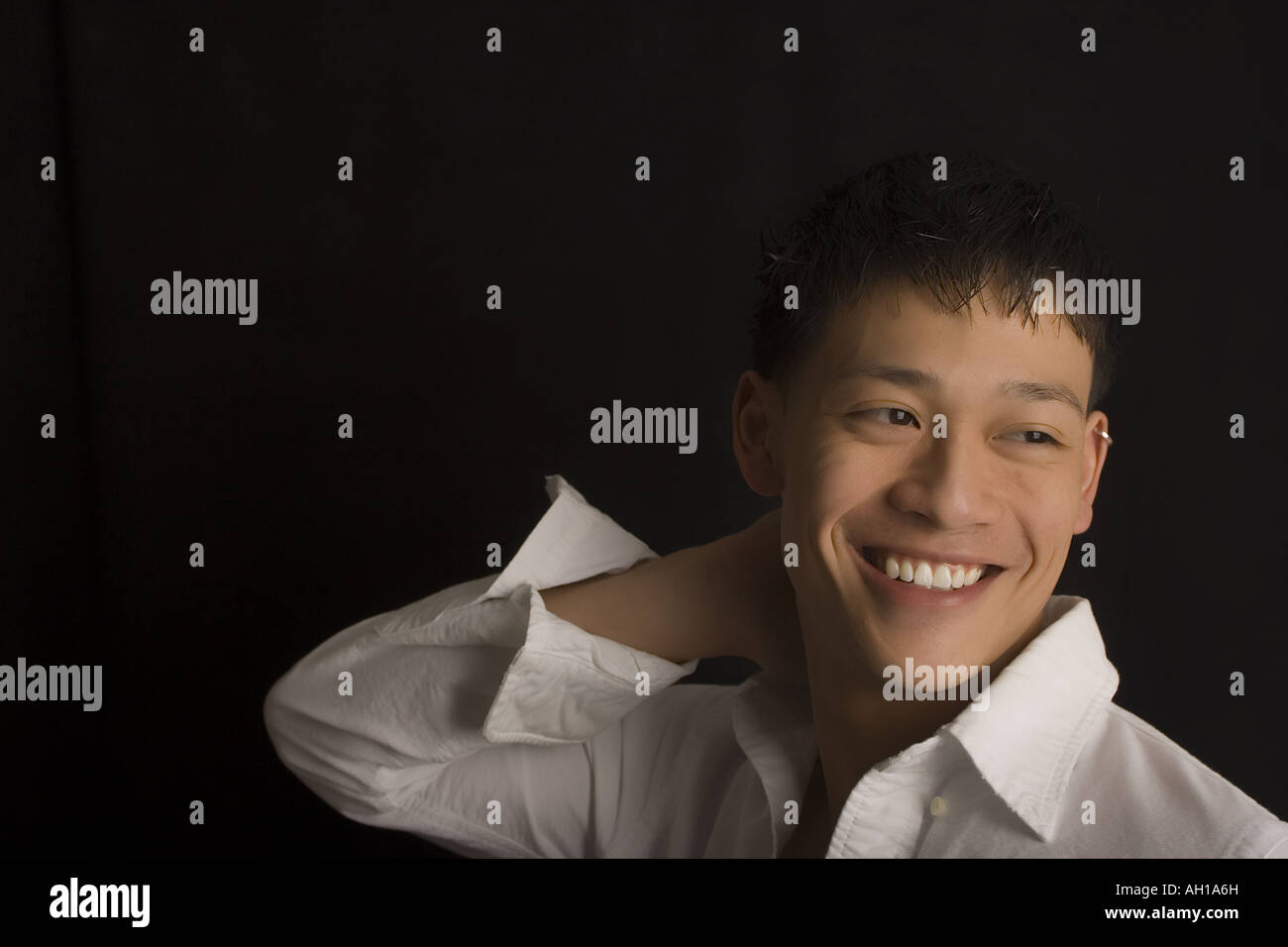 Asian man smiling away from the camera Stock Photo - Alamy