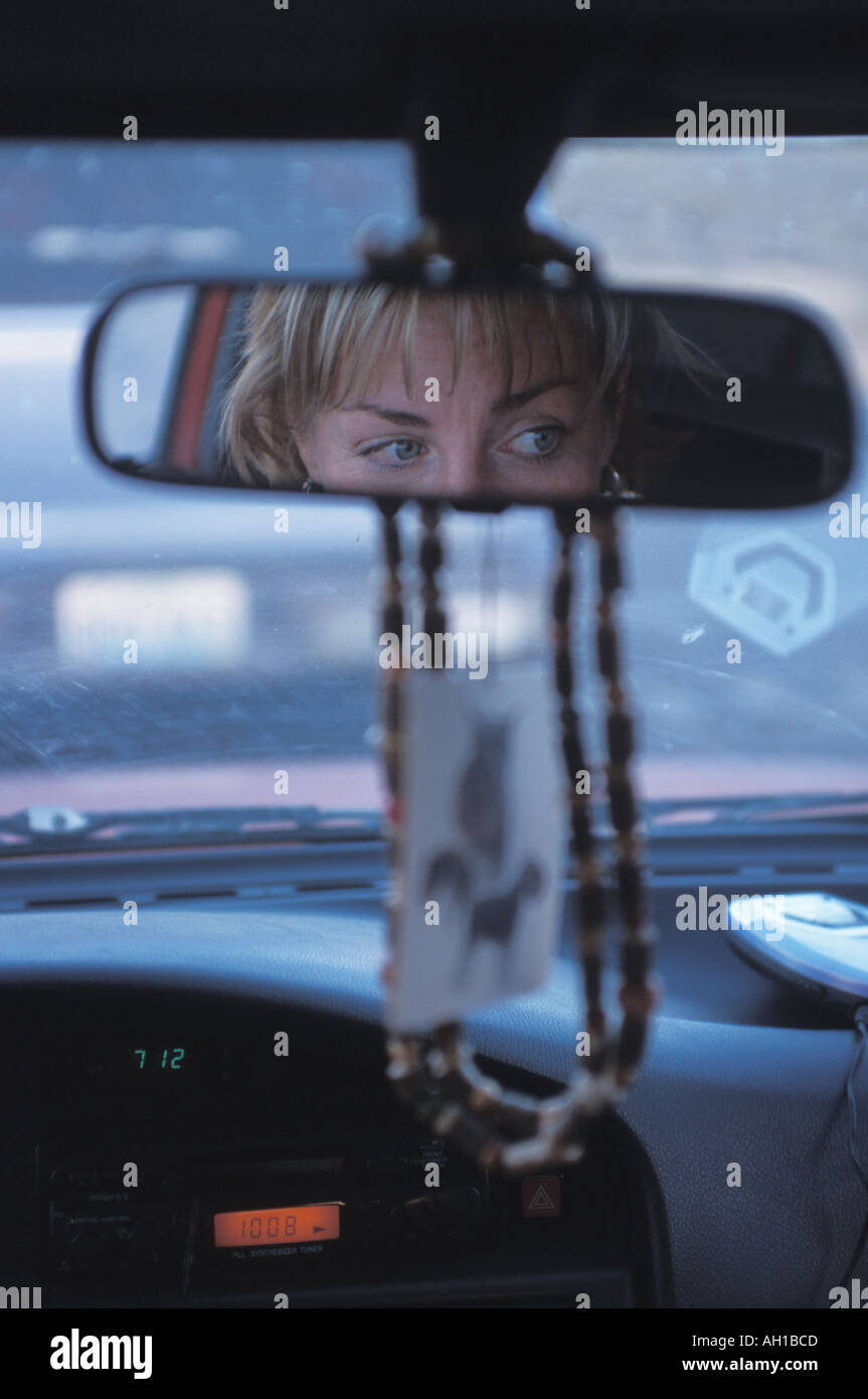 Female looking in her rearview mirror Stock Photo - Alamy