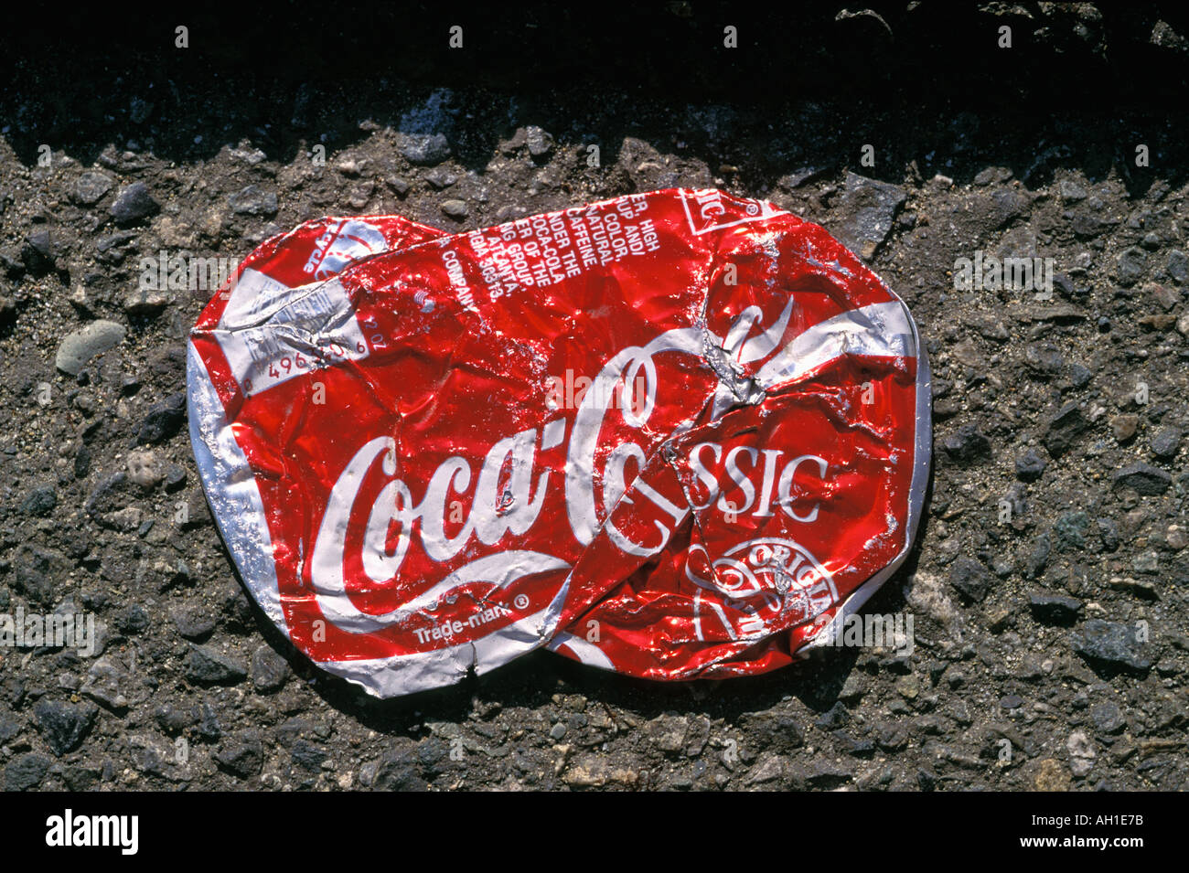 A smashed soda can on a roadway Stock Photo - Alamy