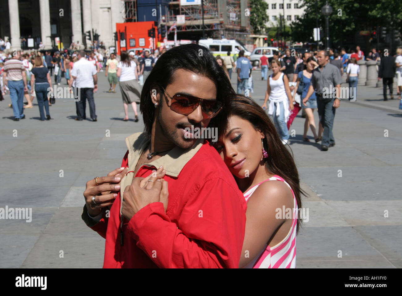 Asian film stars, filming in Trafalgar Square cuddling close together ...