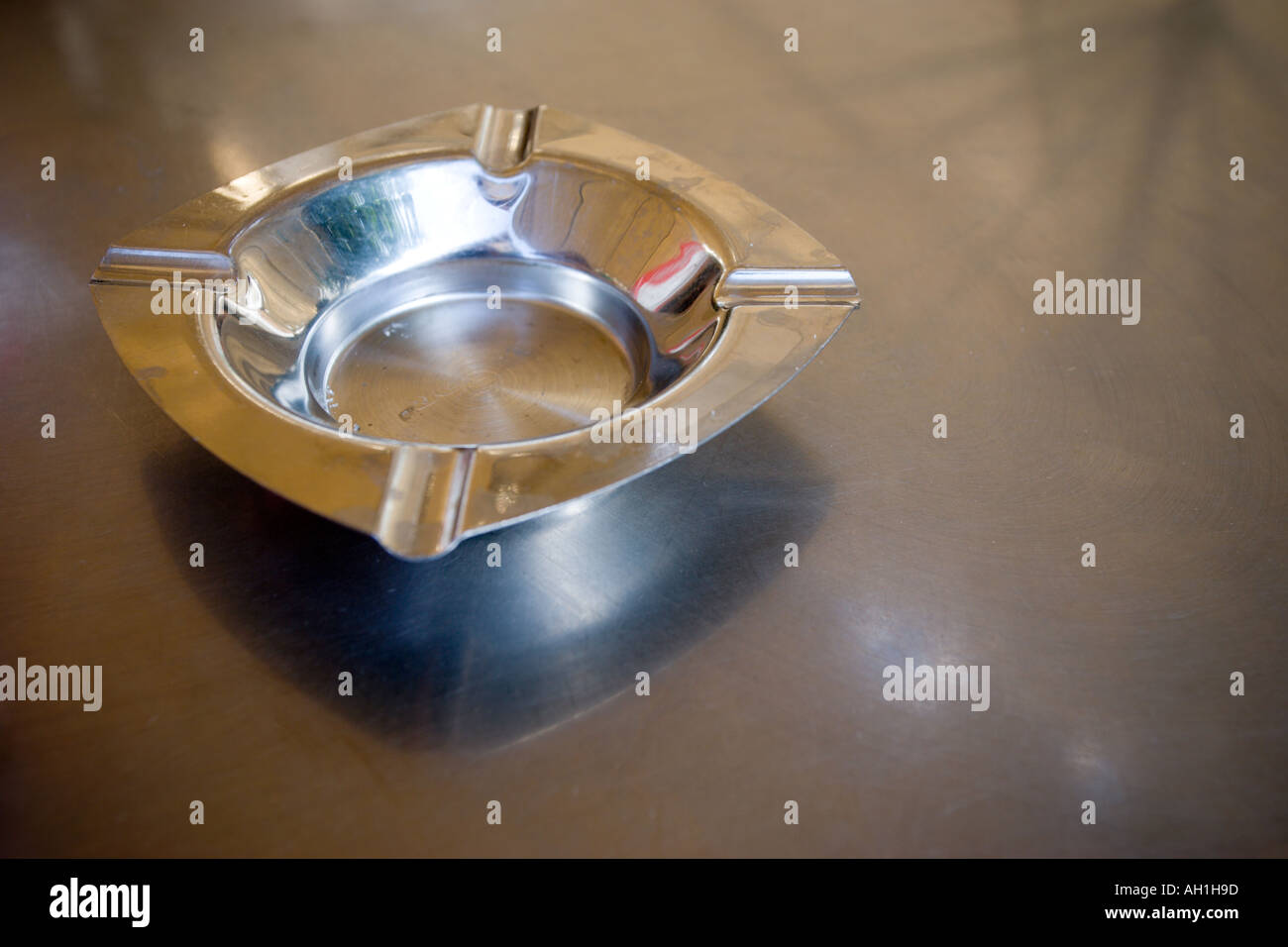 Empty stainless steel ashtray on a metal table Stock Photo - Alamy