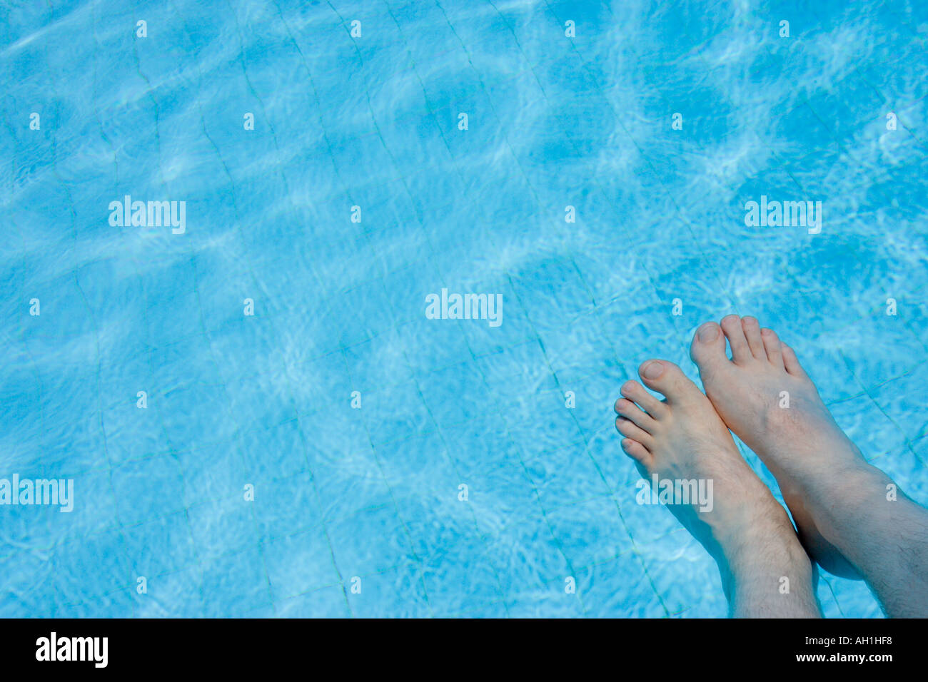 Feet being dipped in a swimming pool Stock Photo - Alamy