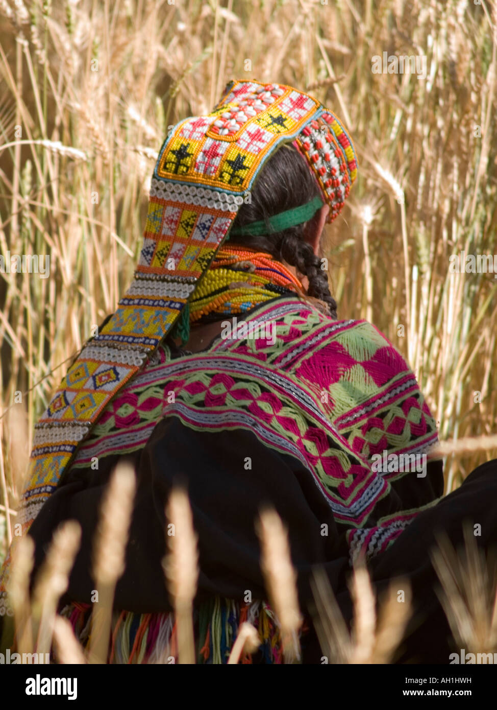 Kalasha woman with traditional colorful headdress in wheat field Stock ...