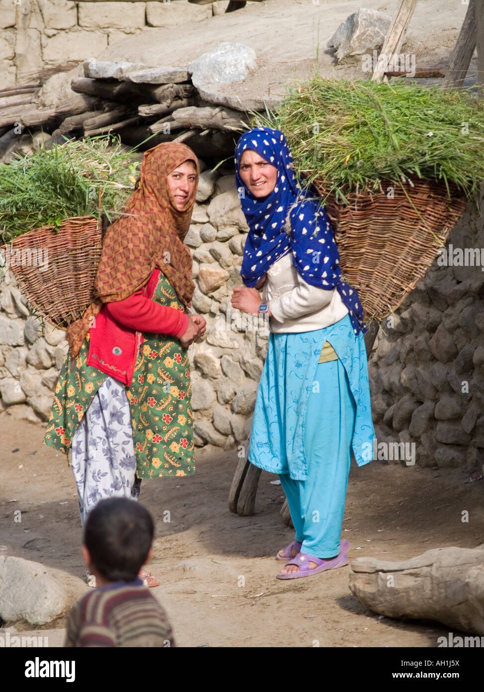 2 covered women in Askole village in Baltistan carrying loads Karakoram ...