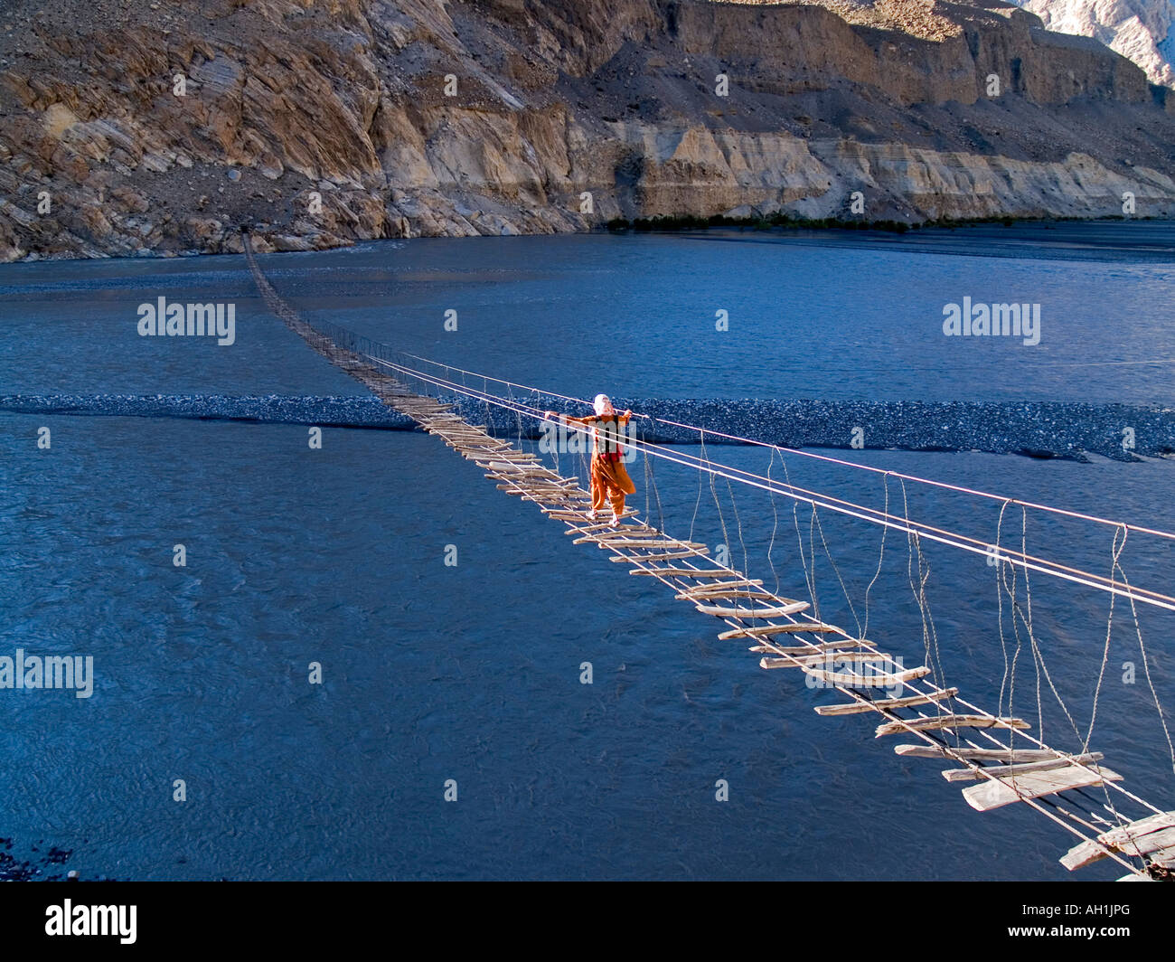 trekker makes the scary crossing of the Hunza River in the Karakoram ...