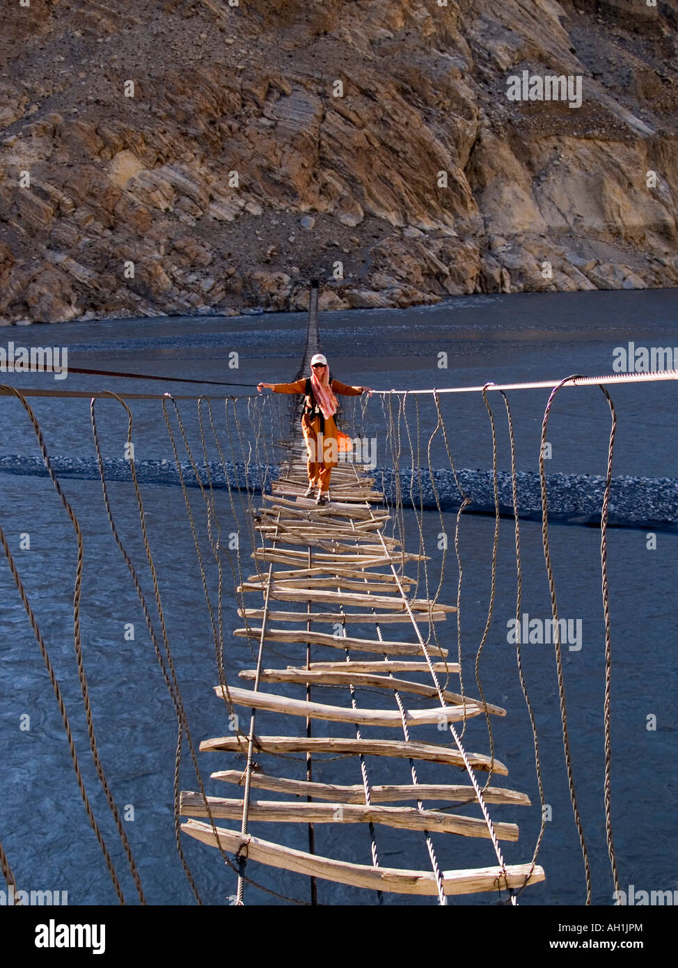 wooden plank bridge spanning the Hunza River in the Karakoram Mountains ...
