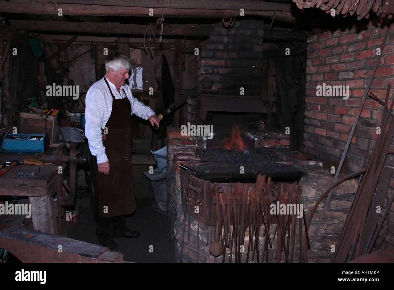 Blacksmith operating forge at Weald and Downland Open Air Museum ...