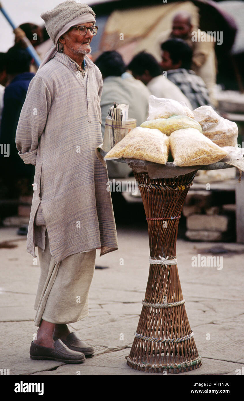 Old mature aged Indian male street vendor selling bags of sneak food on ...