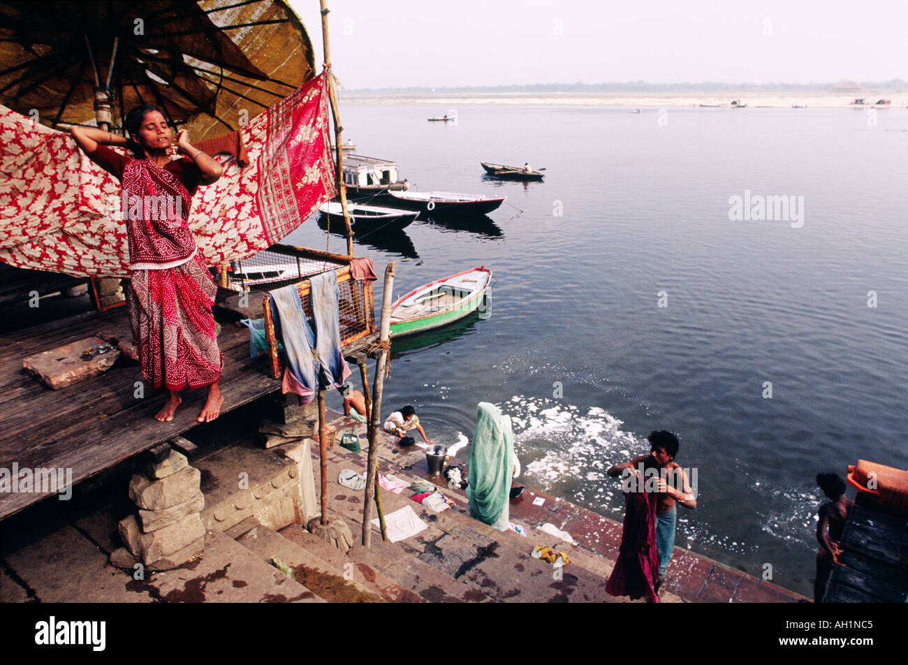 One Indian woman dressing on the Ghat stairs in Varanasi People bathing ...