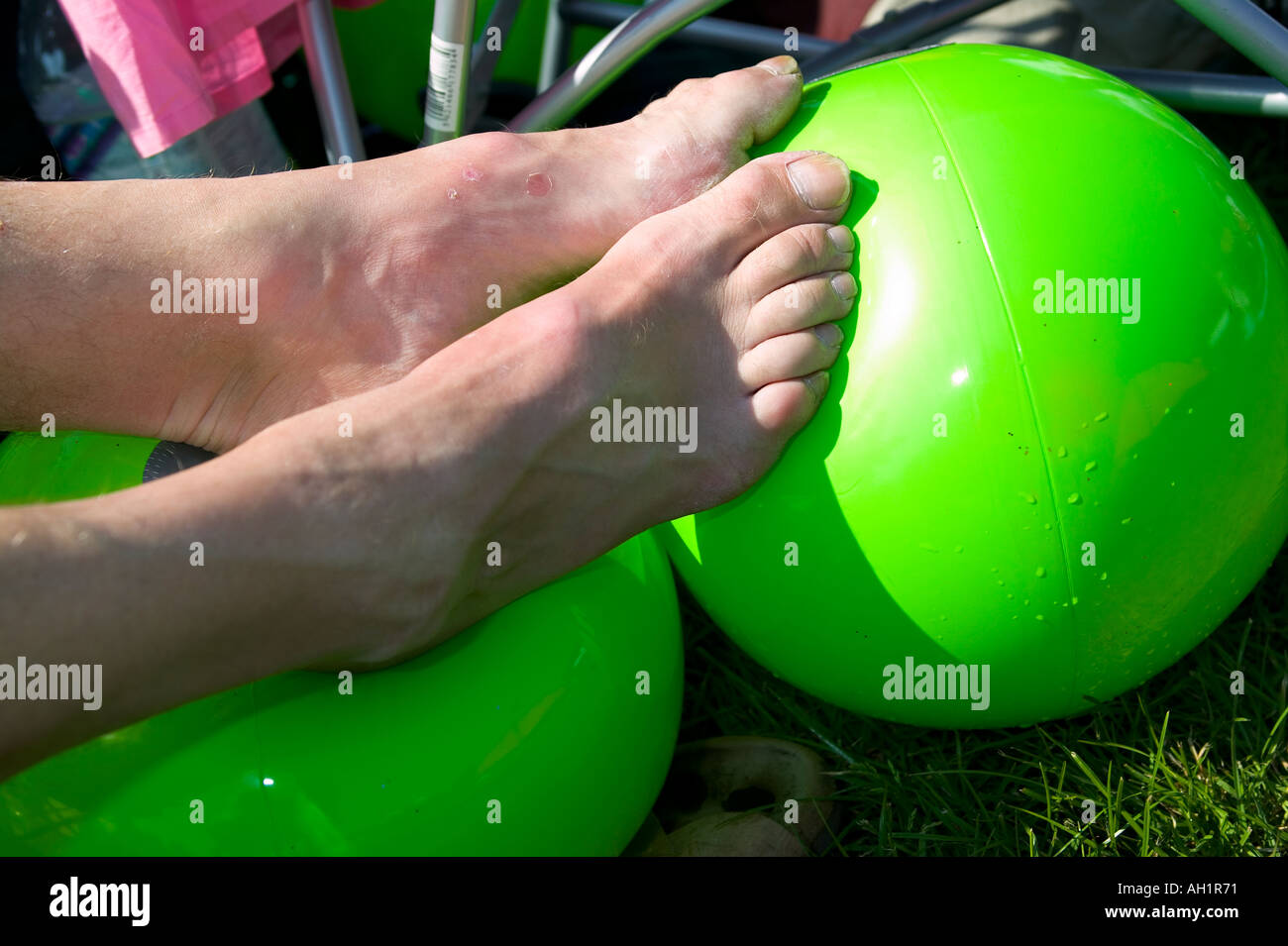 adult male resting feet on two green blow up balls Stock Photo - Alamy