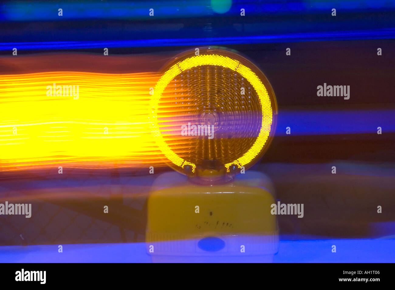 Yellow traffic lantern warning light with yellow and blue light trails ...