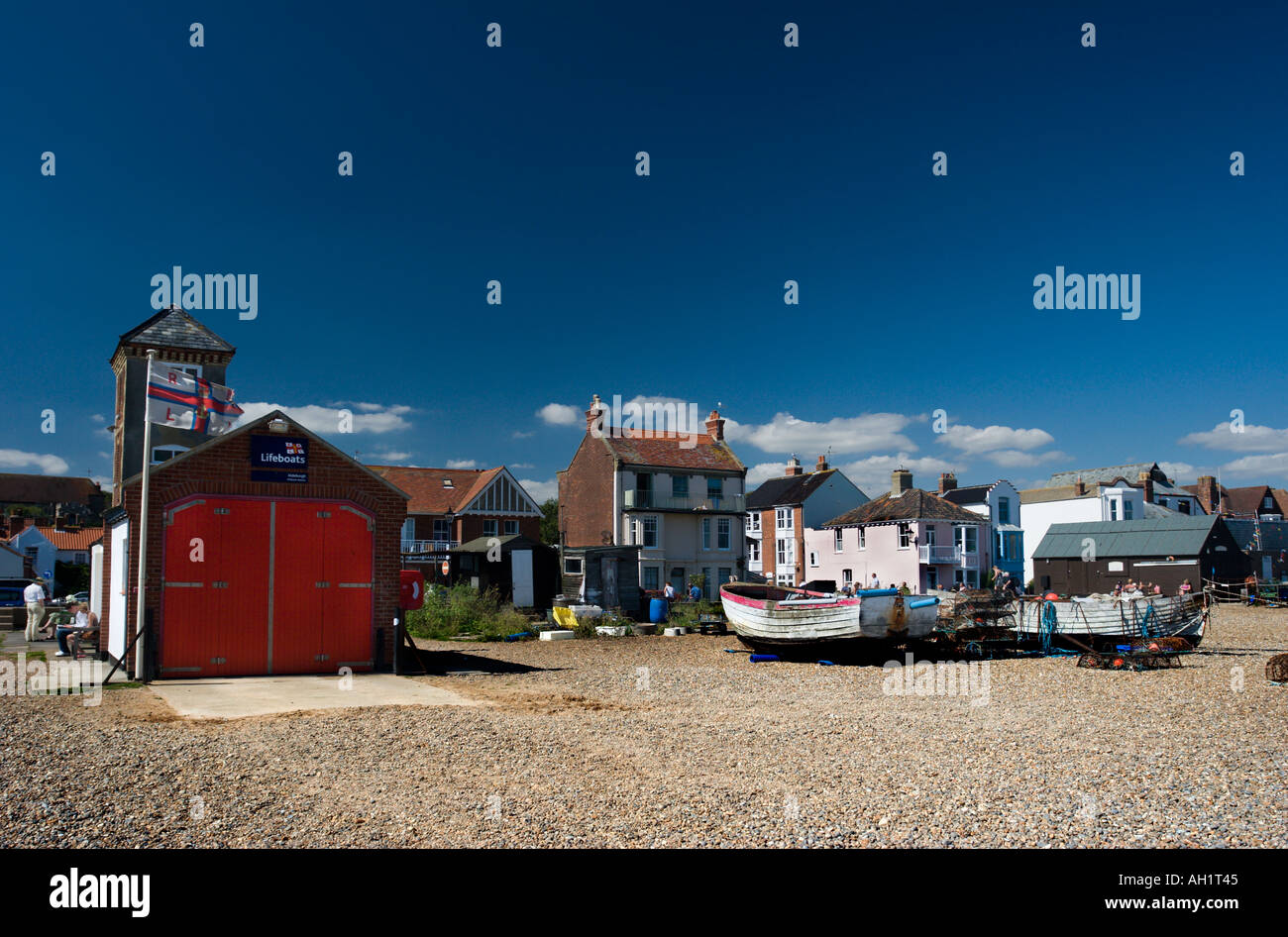 The old RNLI lifeboat station and old fishing boats on the beach at ...