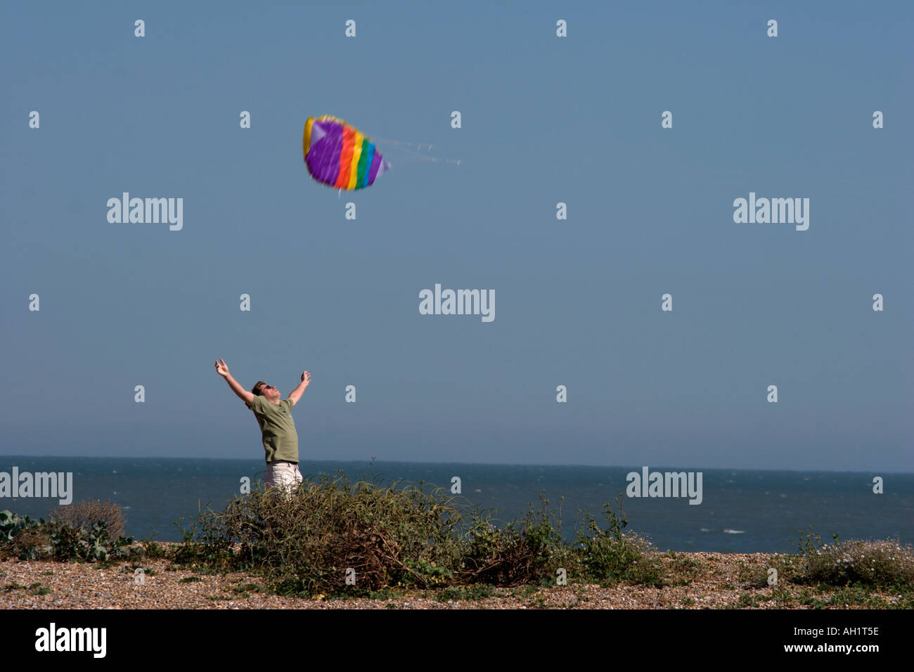A young man releases a kite into the air and it is a blur as it shoots ...
