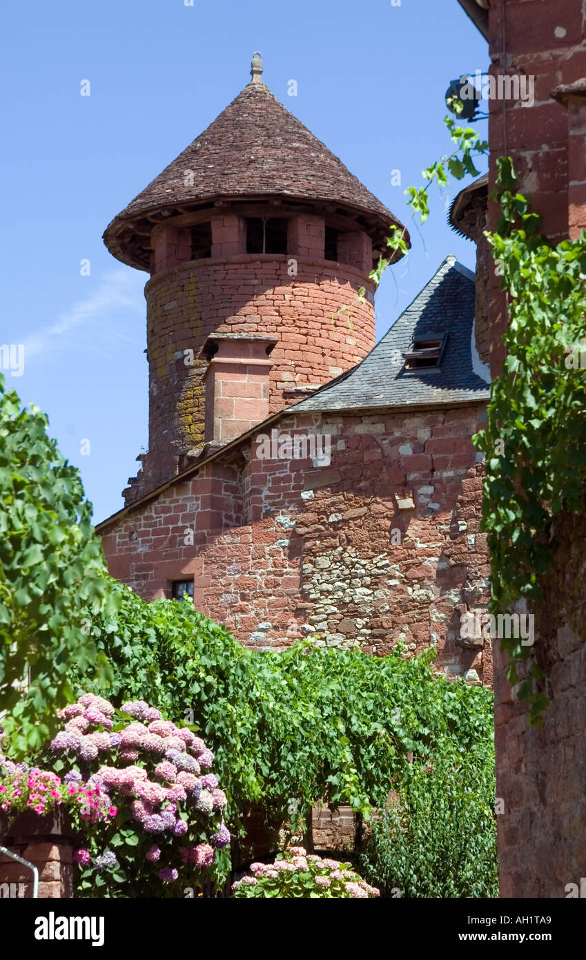 Red stone buildings and old tower with conical tiled roof at Collange ...