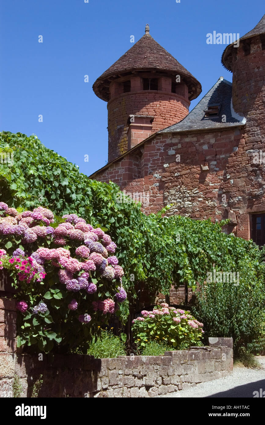 Red stone buildings and old tower with conical tiled roof at Collange ...