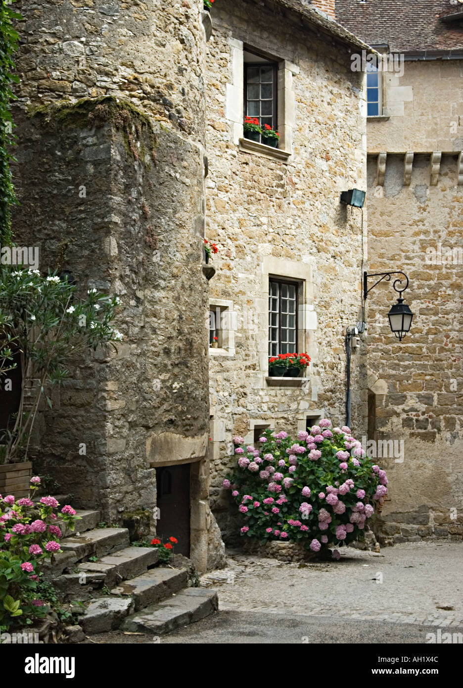 Historic courtyard with old stone buldings decorated with red geraniums ...