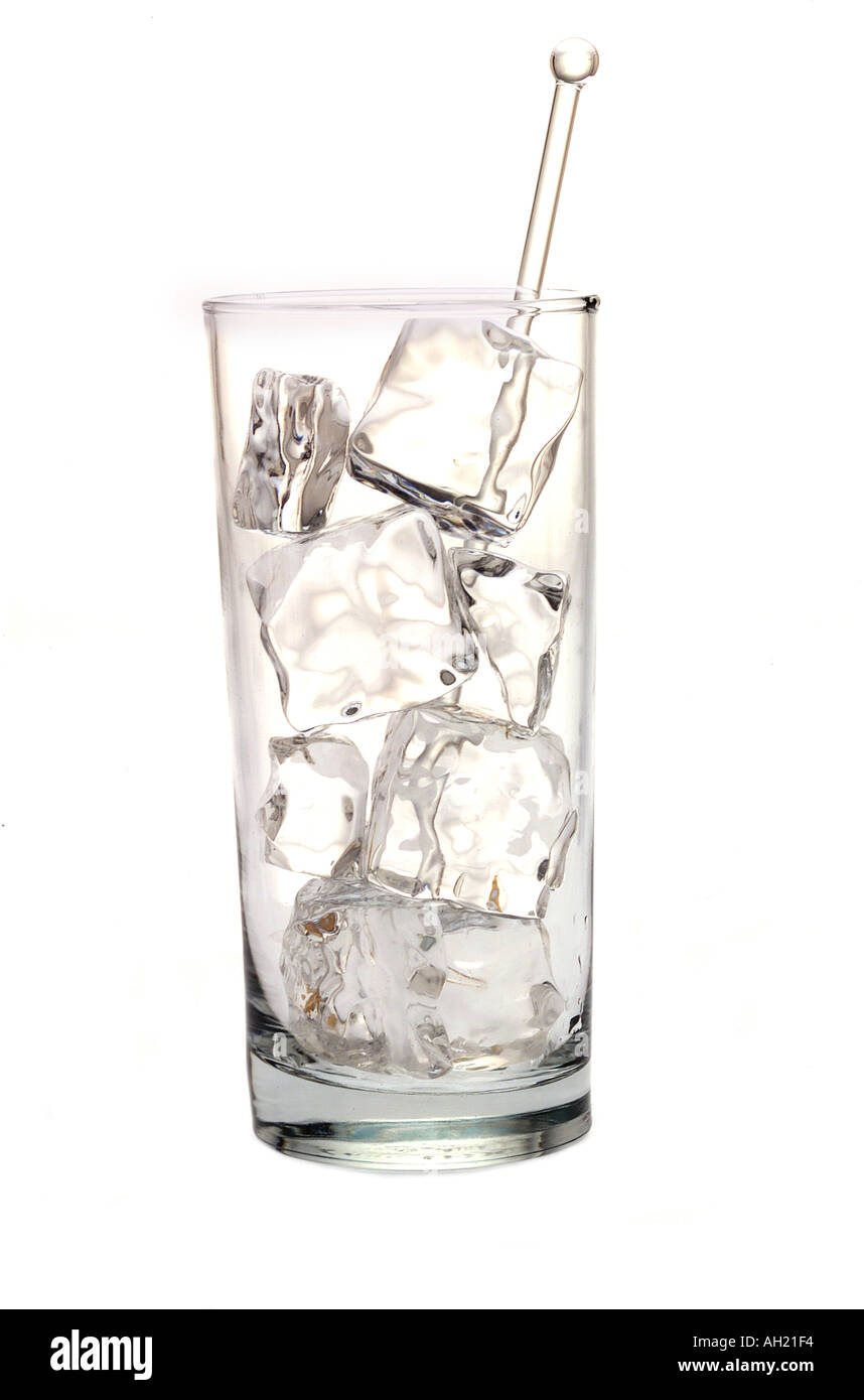 A tall glass of ice with swizzle stick silhouetted on white background ...
