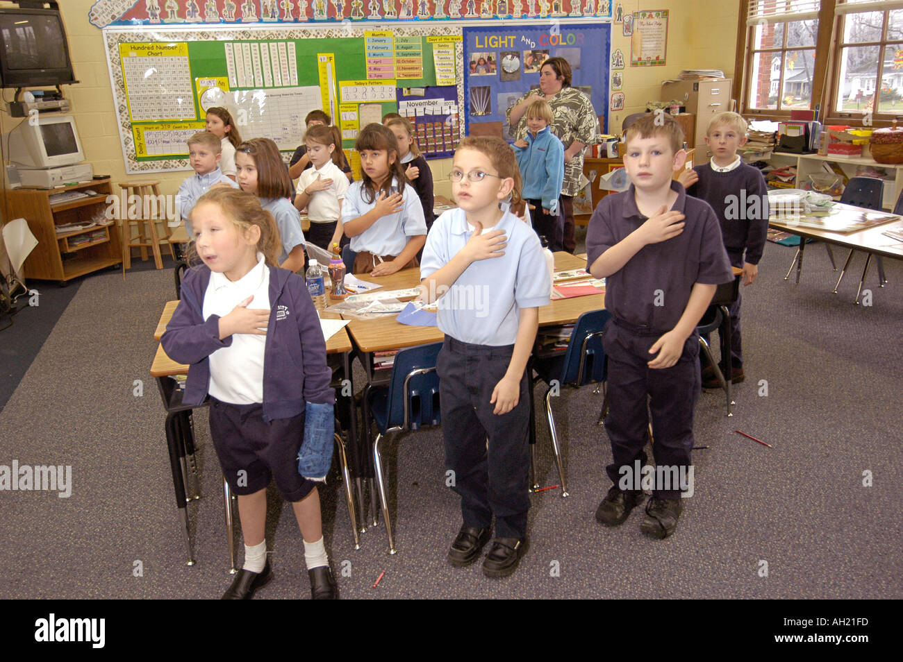 Elementary students say the pledge of allegiance to the American flag ...