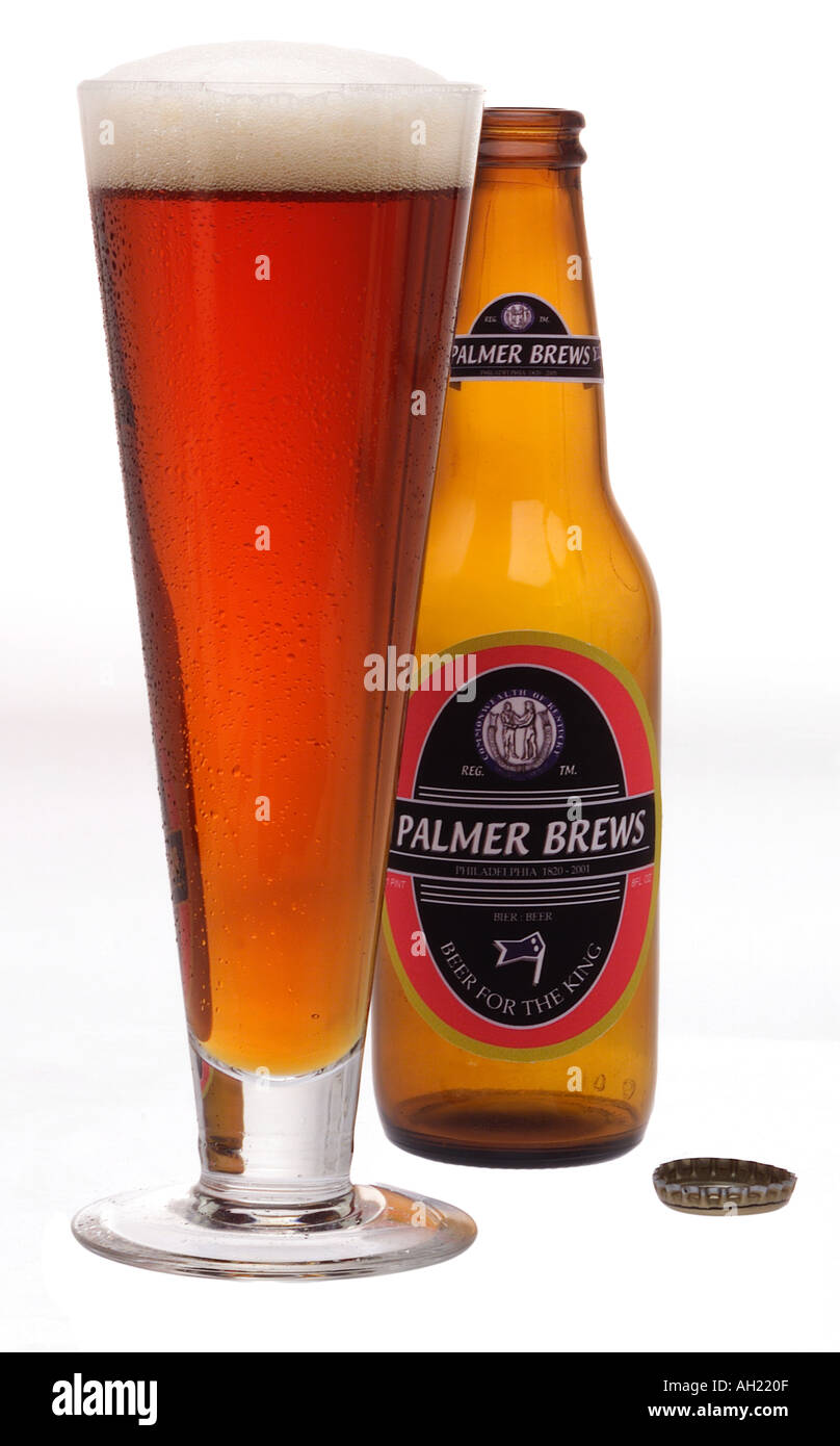 An amber beer in a Pilsner glass and empty bottle with studio produced ...