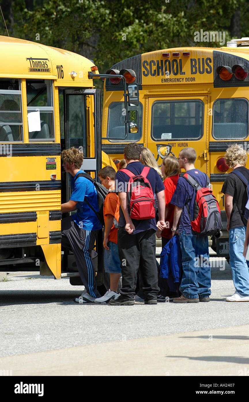 Students Board a School Bus to ride home after the end to the school ...
