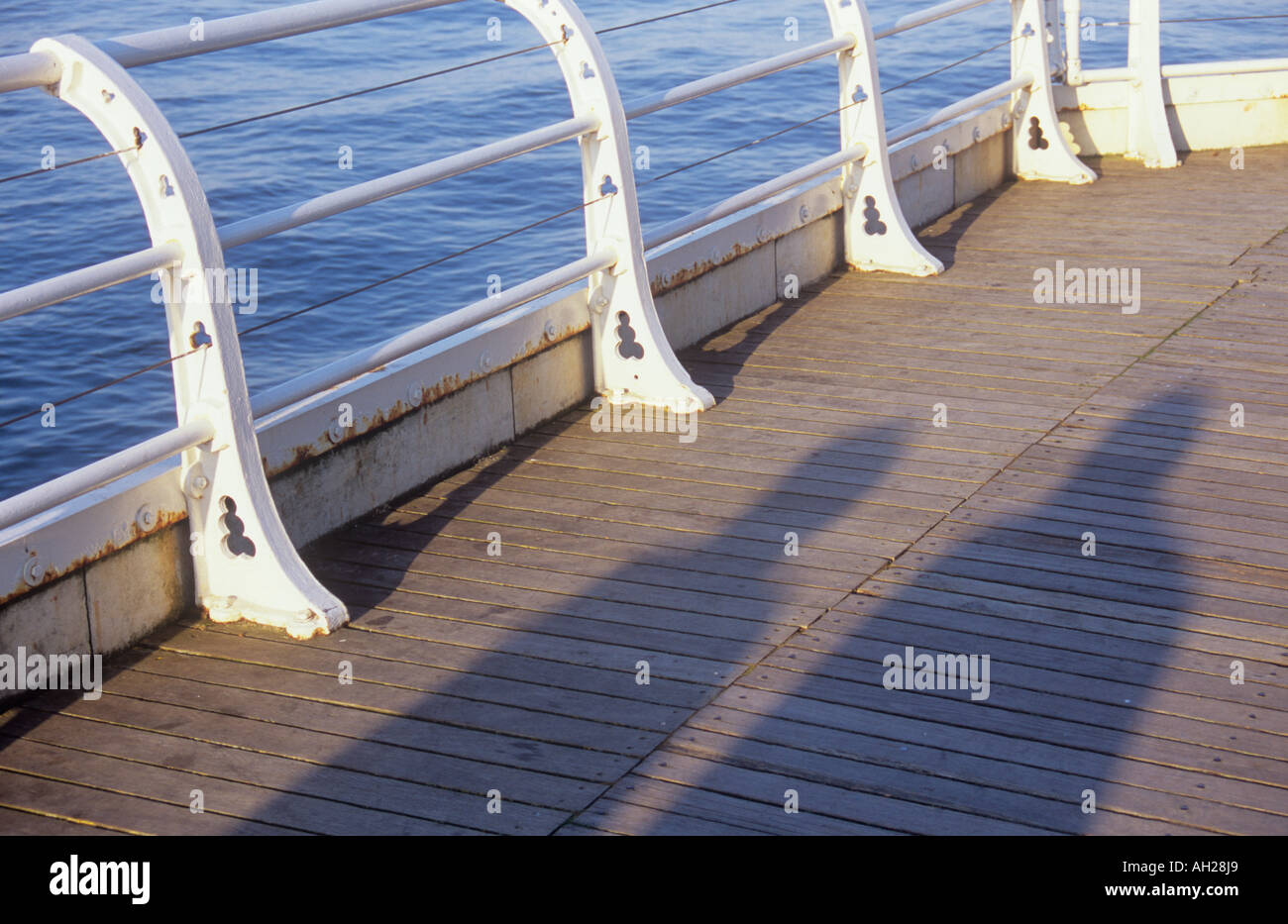 Part of a seaside boardwalk or pier with white railings and swelling ...