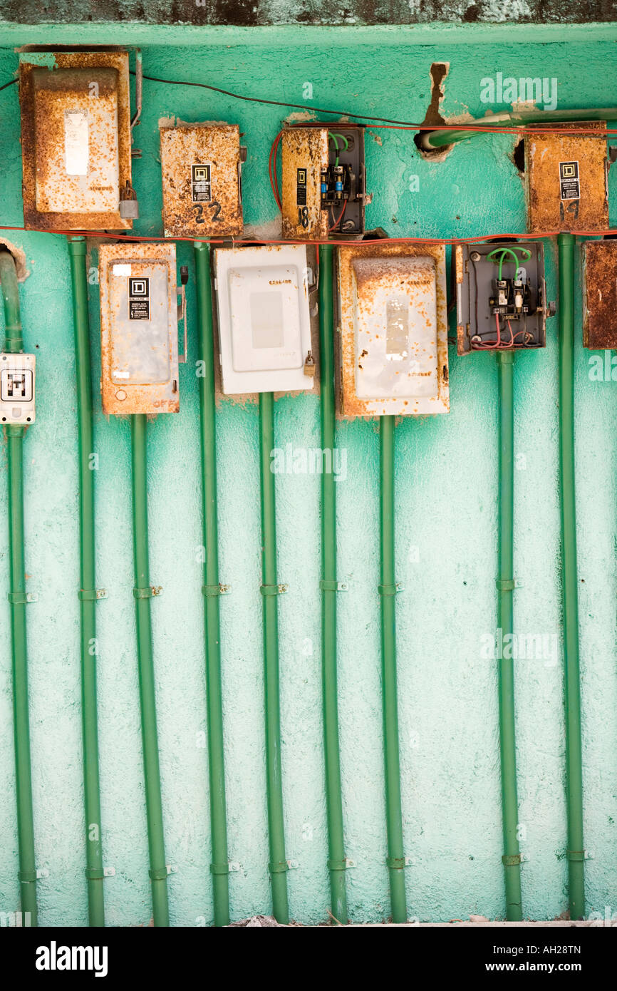 Many rusted electric panels on a green wall Stock Photo - Alamy