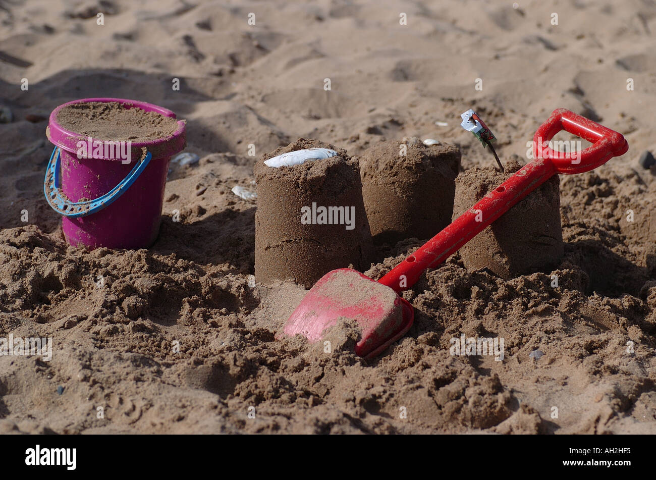 Sandcastles and a bucket and spade on a beach Stock Photo - Alamy