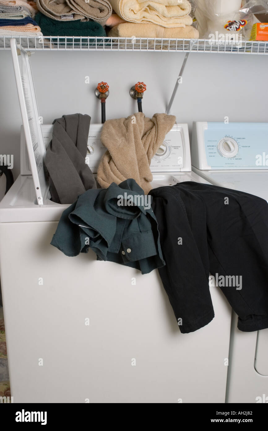 laundry machine overflowing with clothes Stock Photo - Alamy