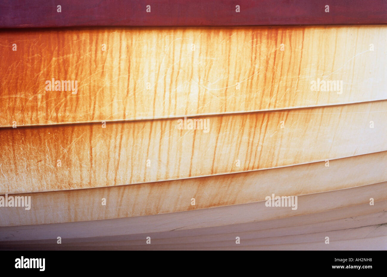 Side of the hull of a boat or ship painted white and red and covered ...