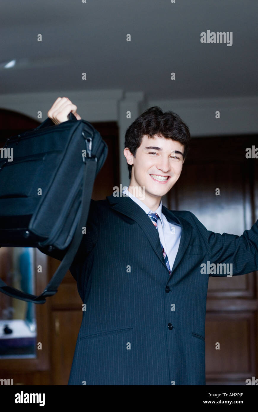 Portrait of a businessman carrying a briefcase and smiling Stock Photo ...