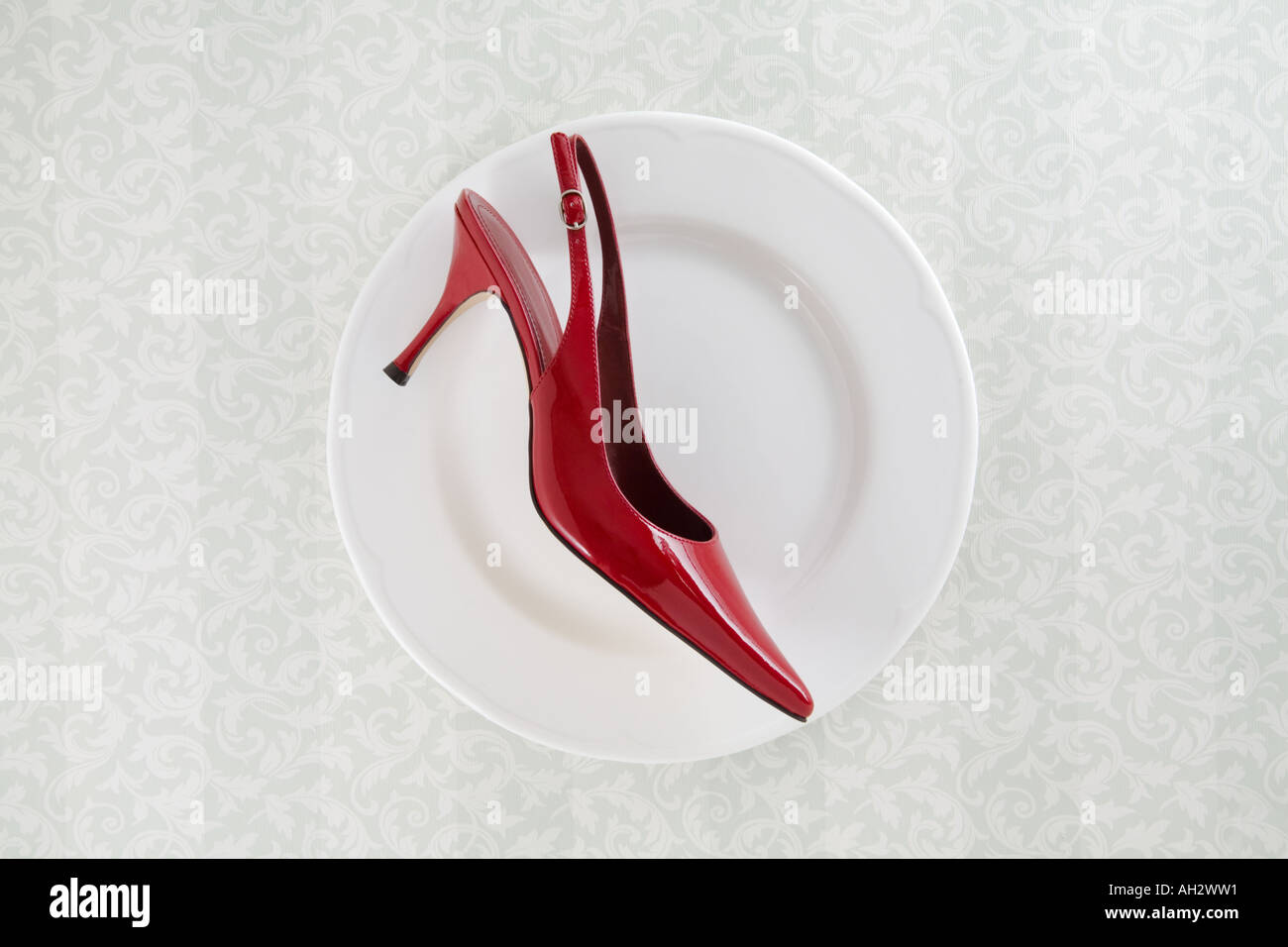 red high heel on white plate studio shot Stock Photo - Alamy