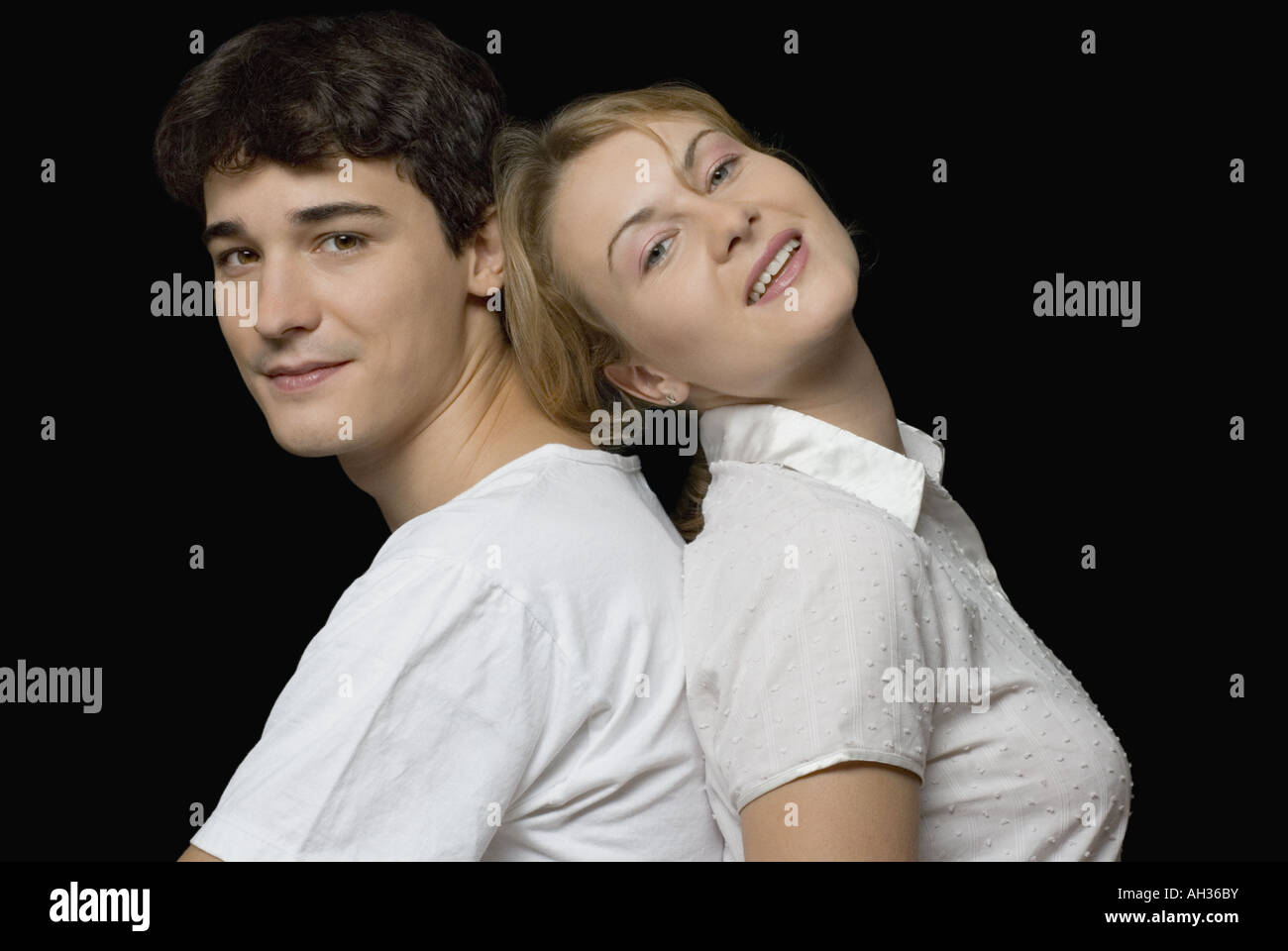 Portrait of a young couple back to back Stock Photo - Alamy