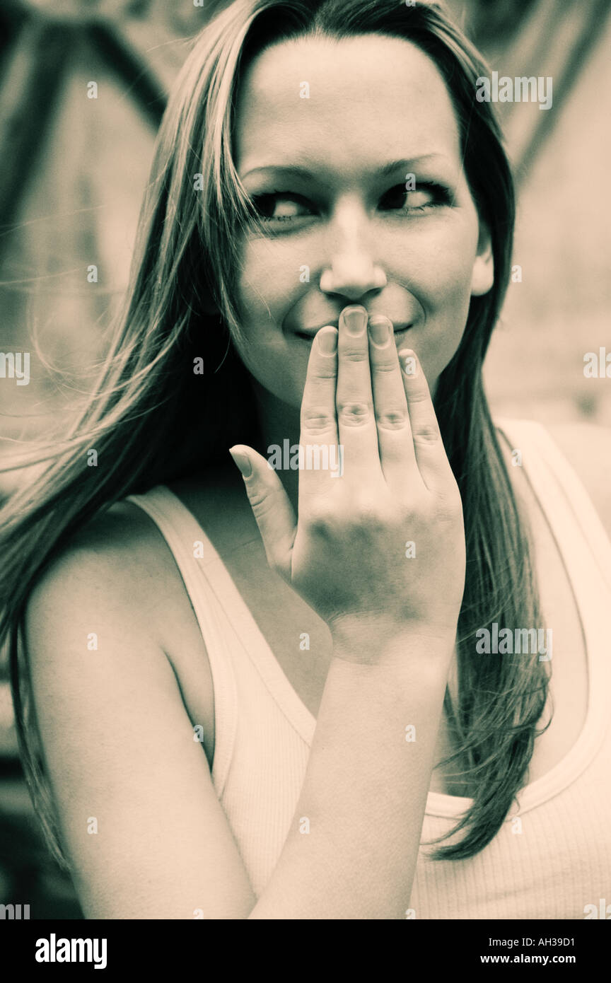 Young woman with hand over mouth Stock Photo - Alamy