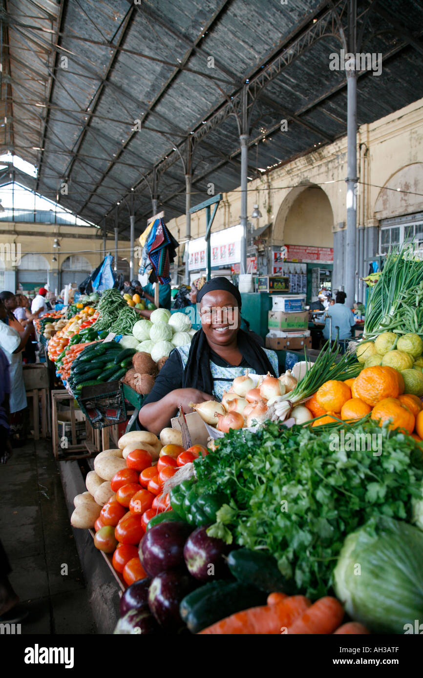 Black African woman with friendly smile selling vegetables and fruits ...