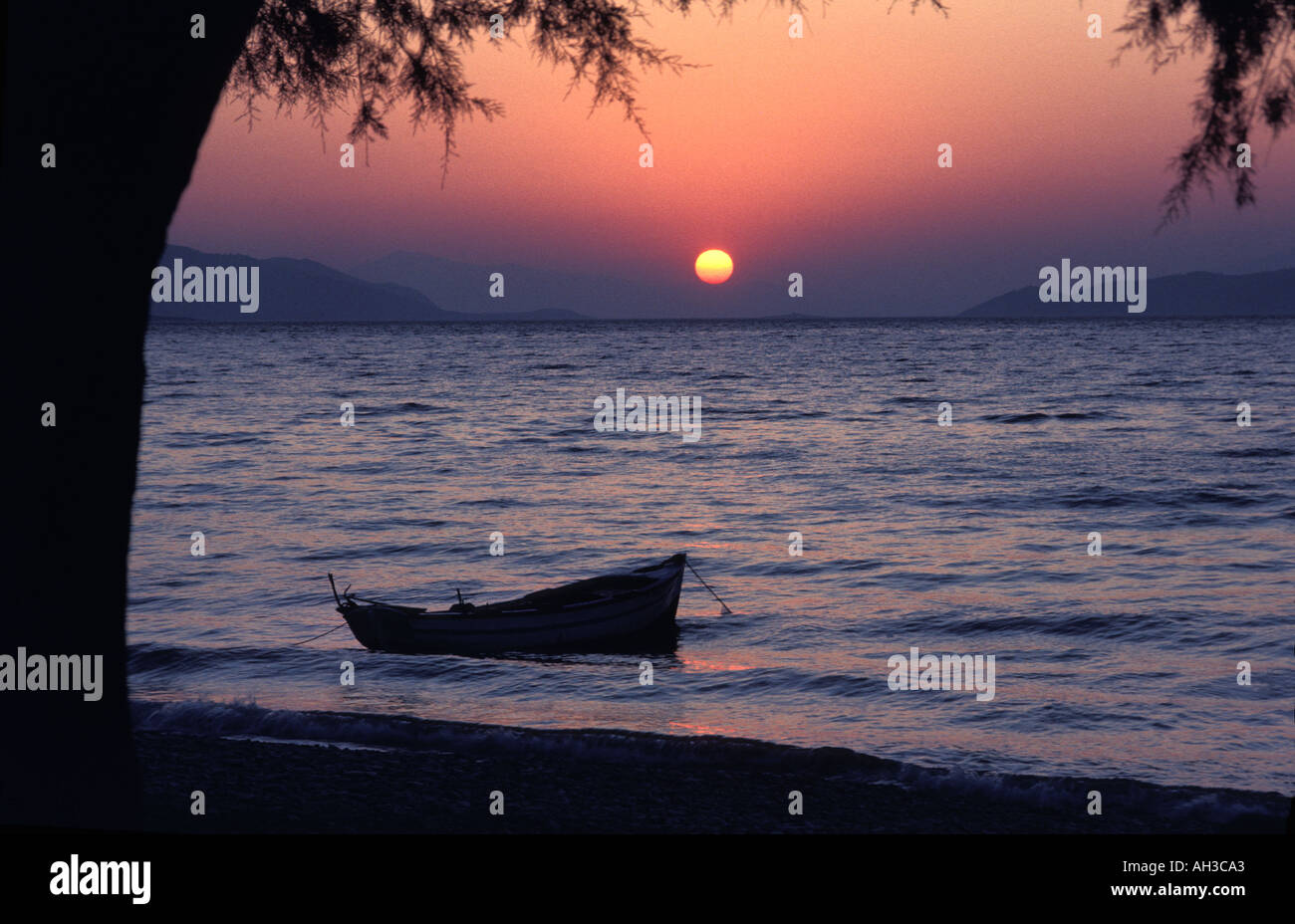 Rowing boat at sunset on Greek Island of Samos Stock Photo - Alamy